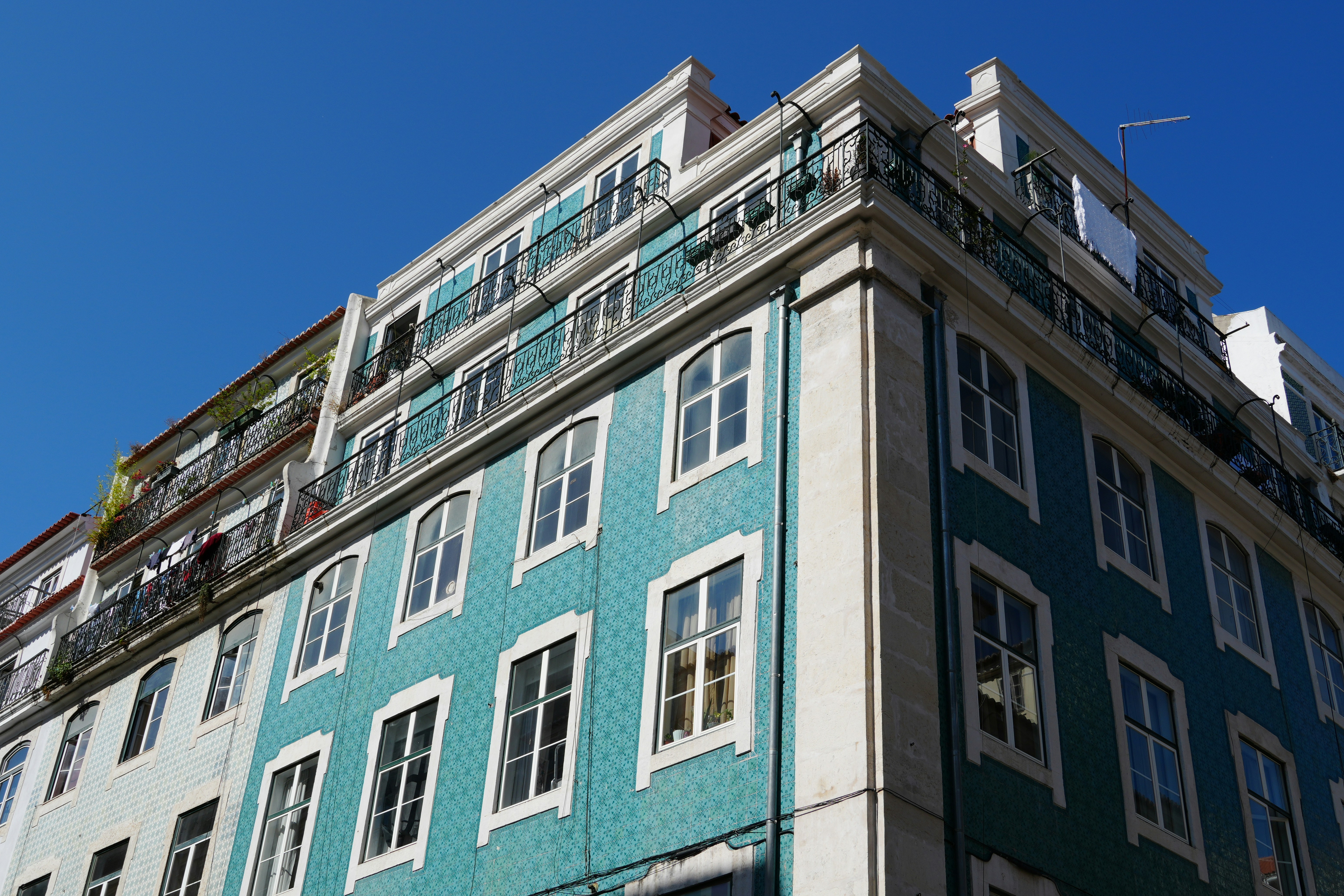 Teal tiled building facade with white trim windows.