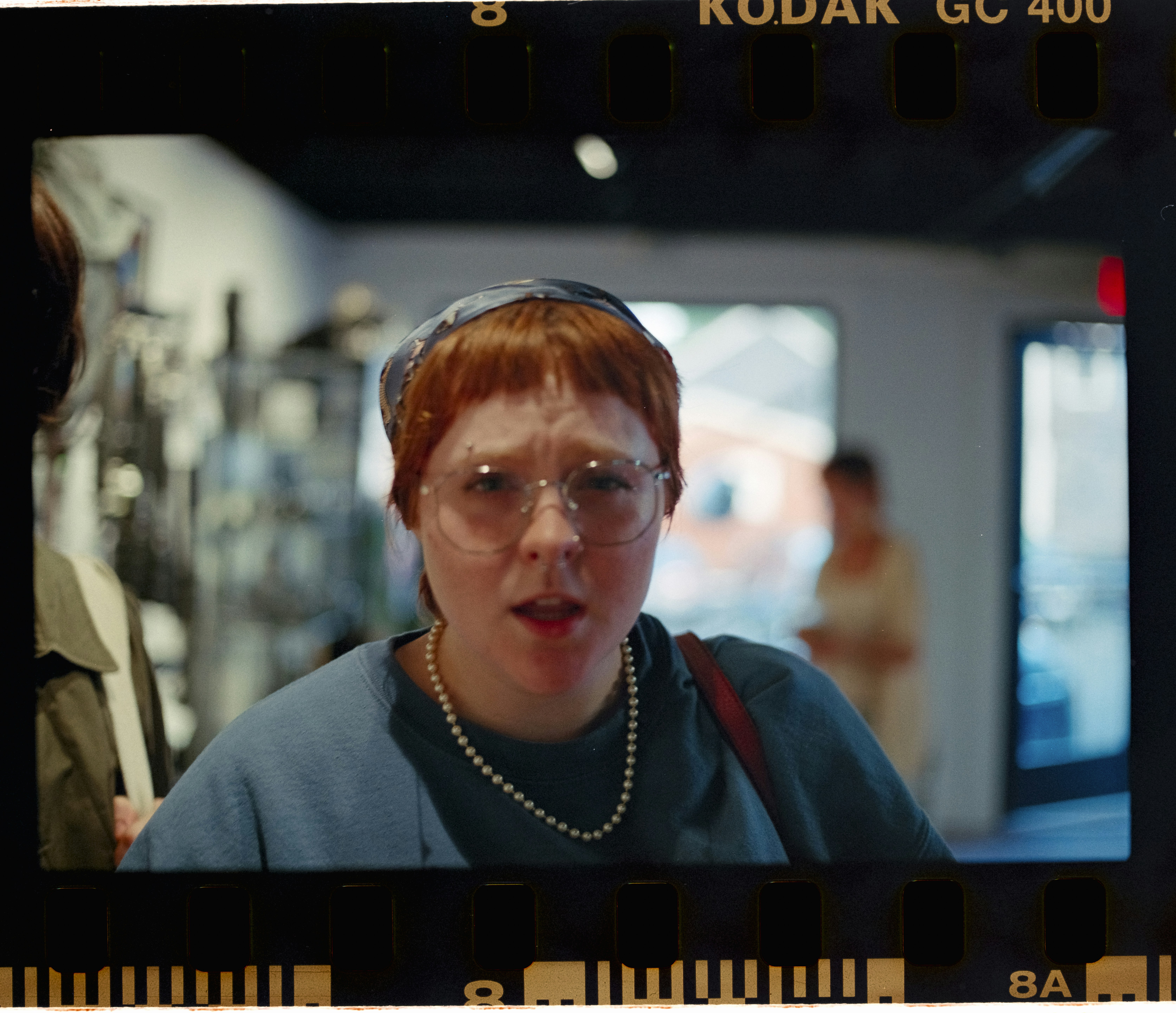 Woman with red hair and glasses looks surprised.