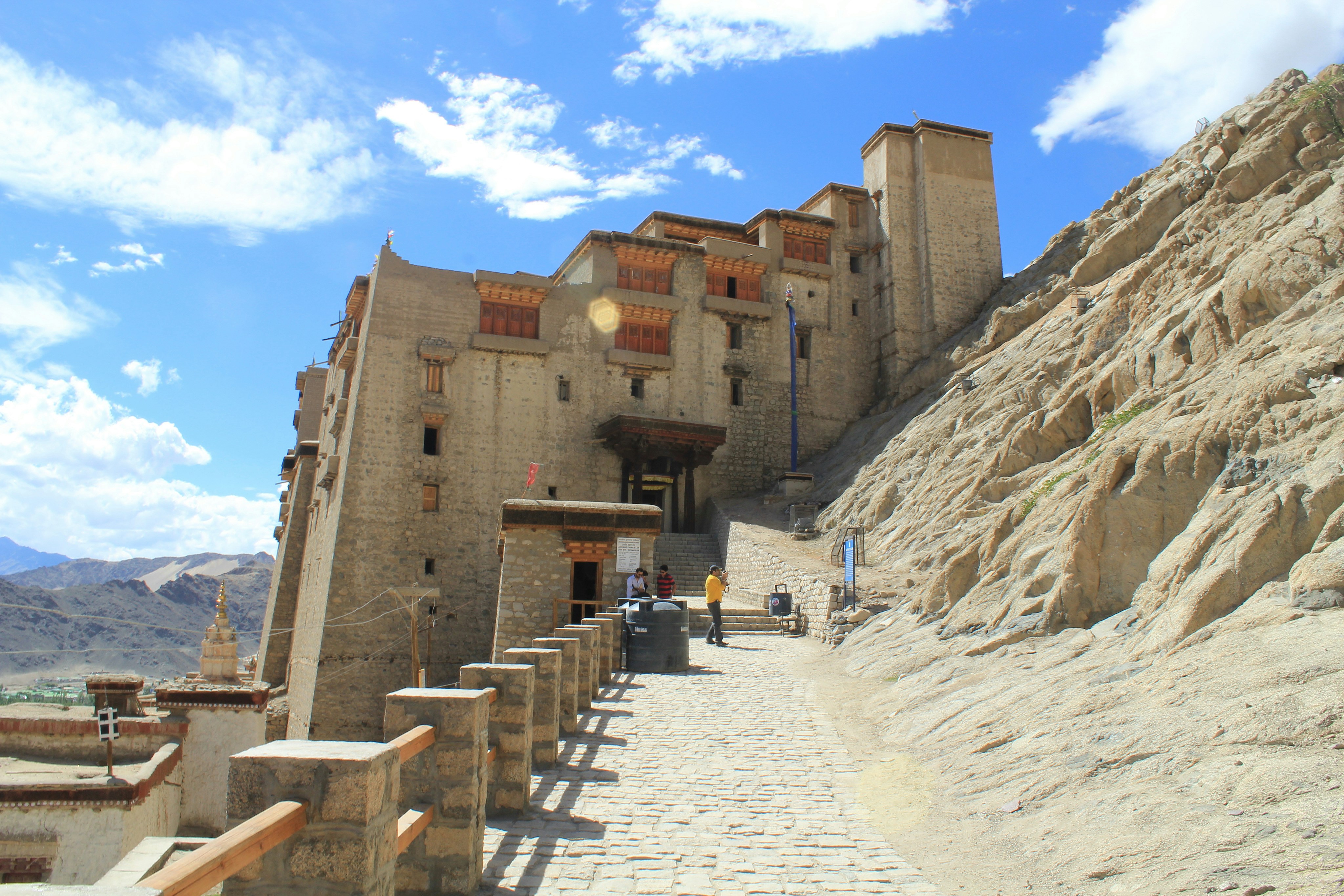 400 years old palace of Ladakhi king. | Ancient fortress built into a rocky mountainside under blue sky.