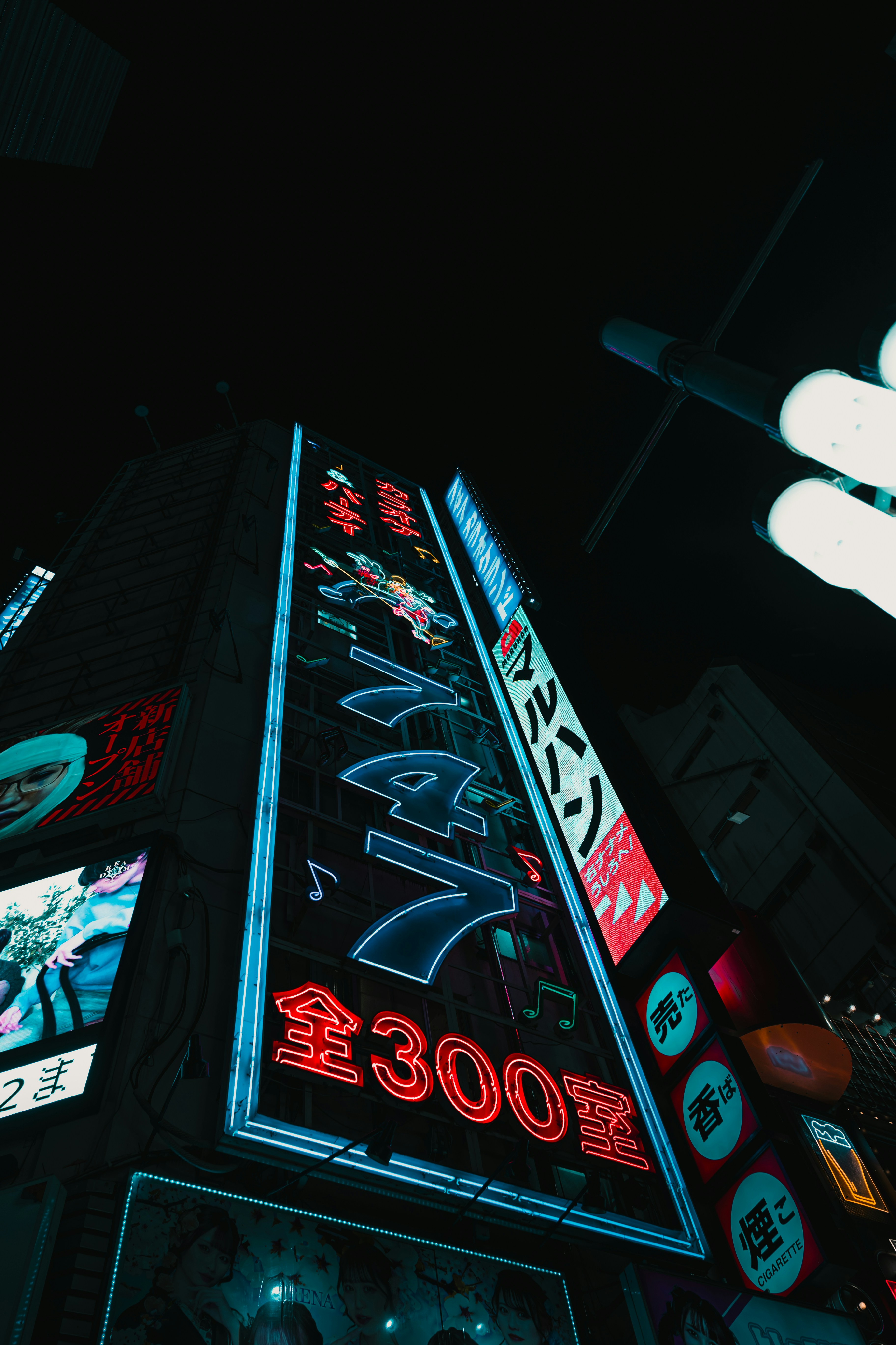Vibrant neon signs illuminating a bustling urban scene at night, showcasing the energy of city life. The composition highlights the interplay of light and shadows.