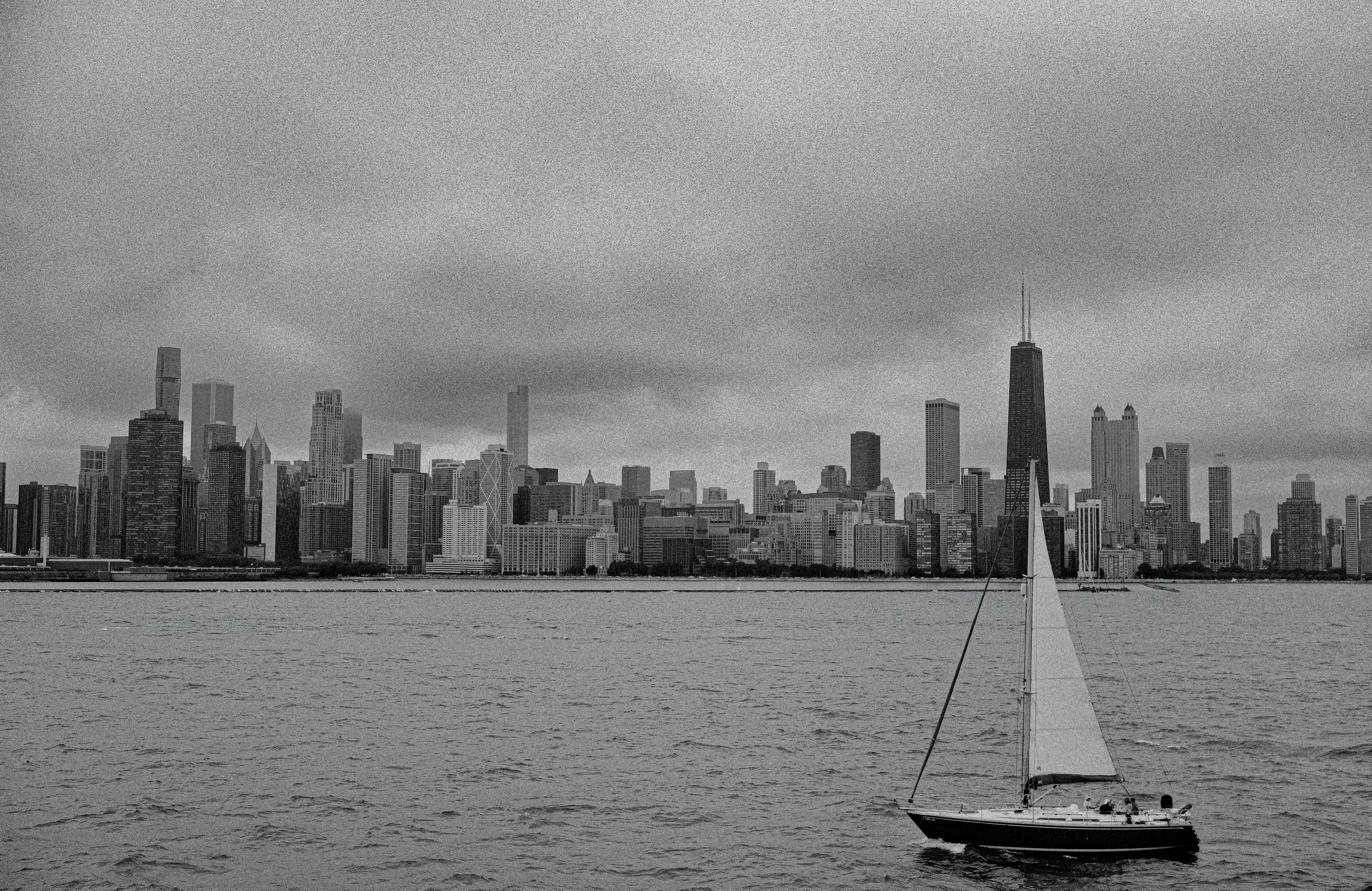 Chicago skyline from lake Michigan with a sail boat in foreground | Sailboat on water with city skyline background