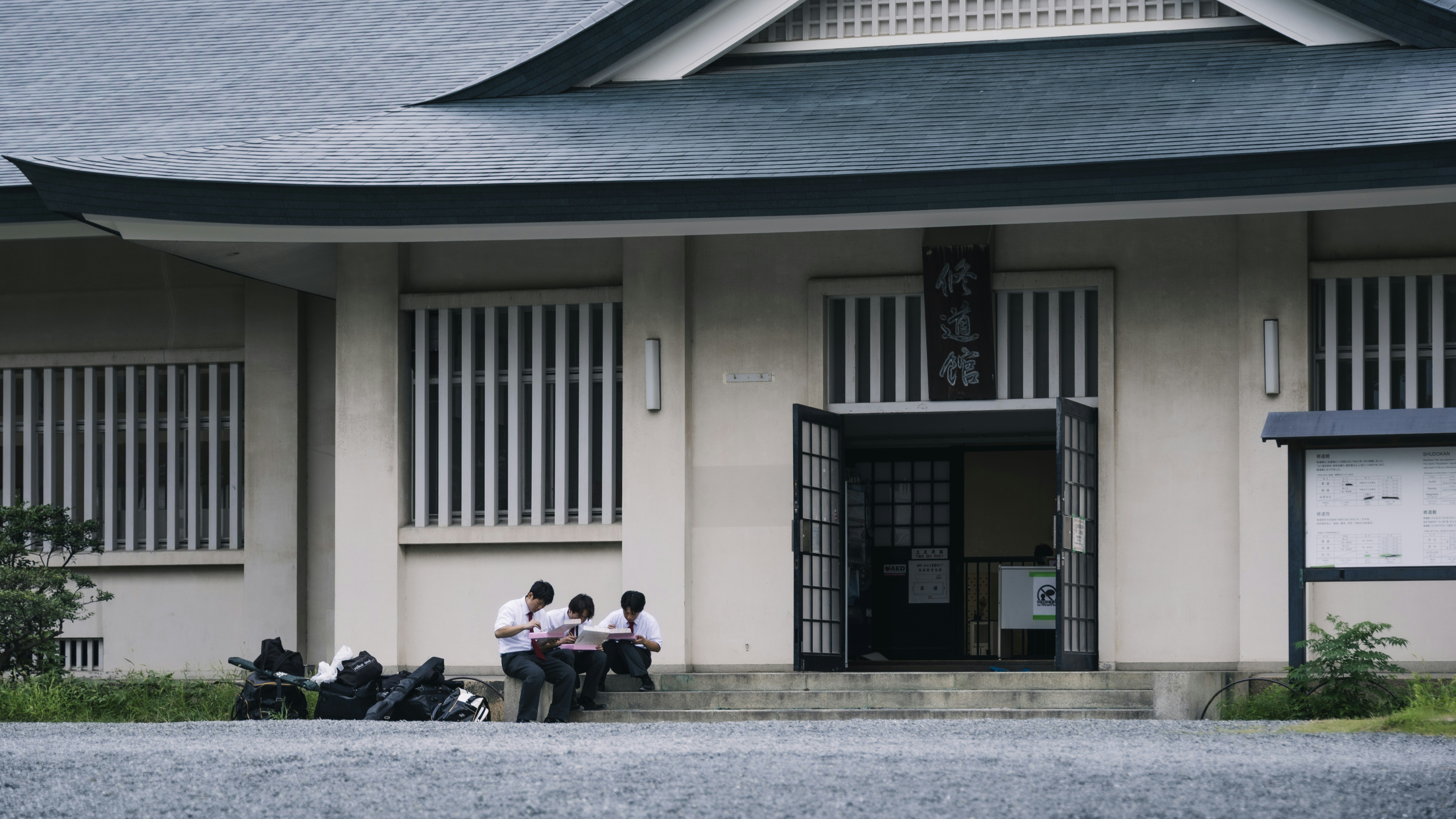 Students sitting outside a traditional japanese building.