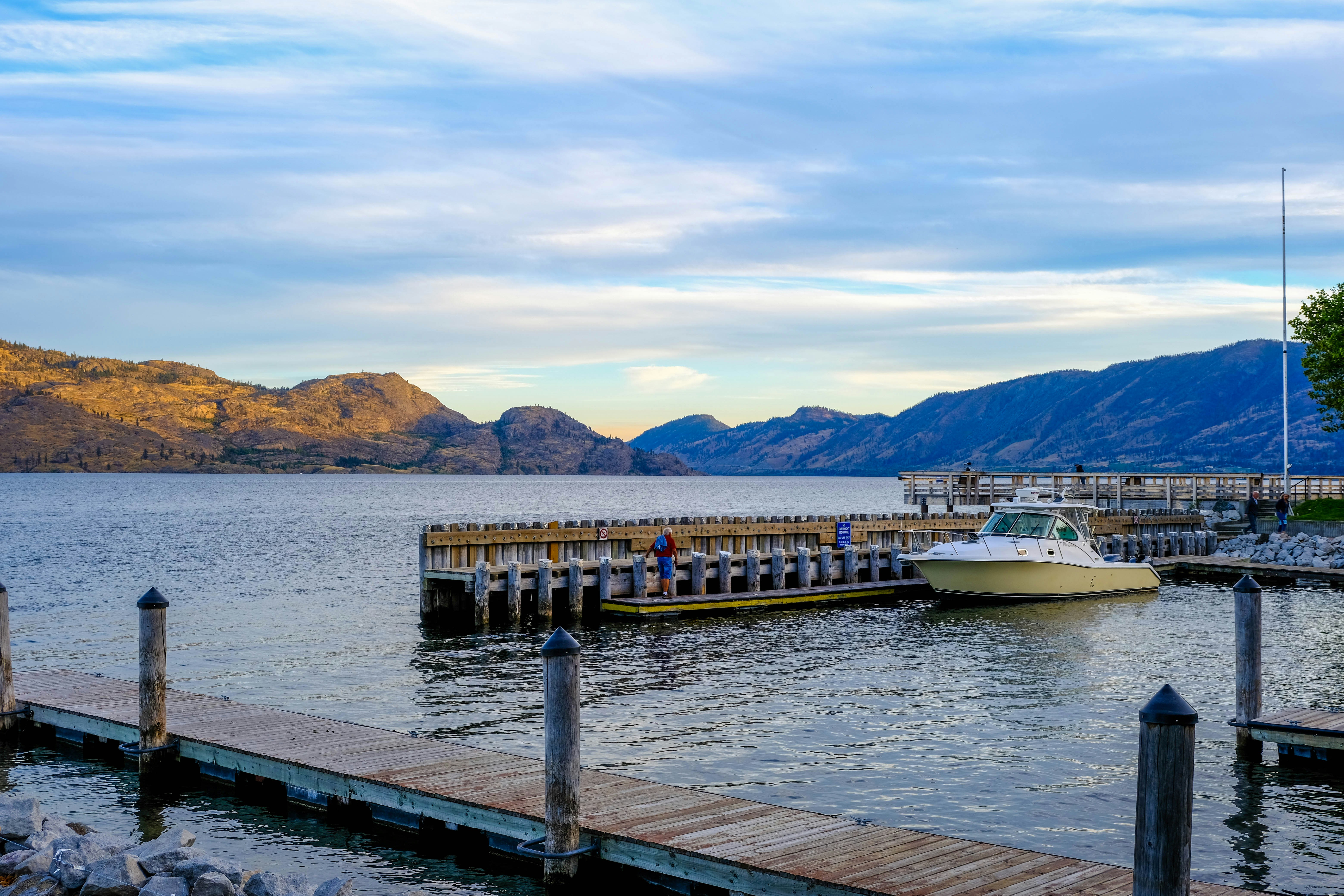 Boat docked at a pier with mountains in background.