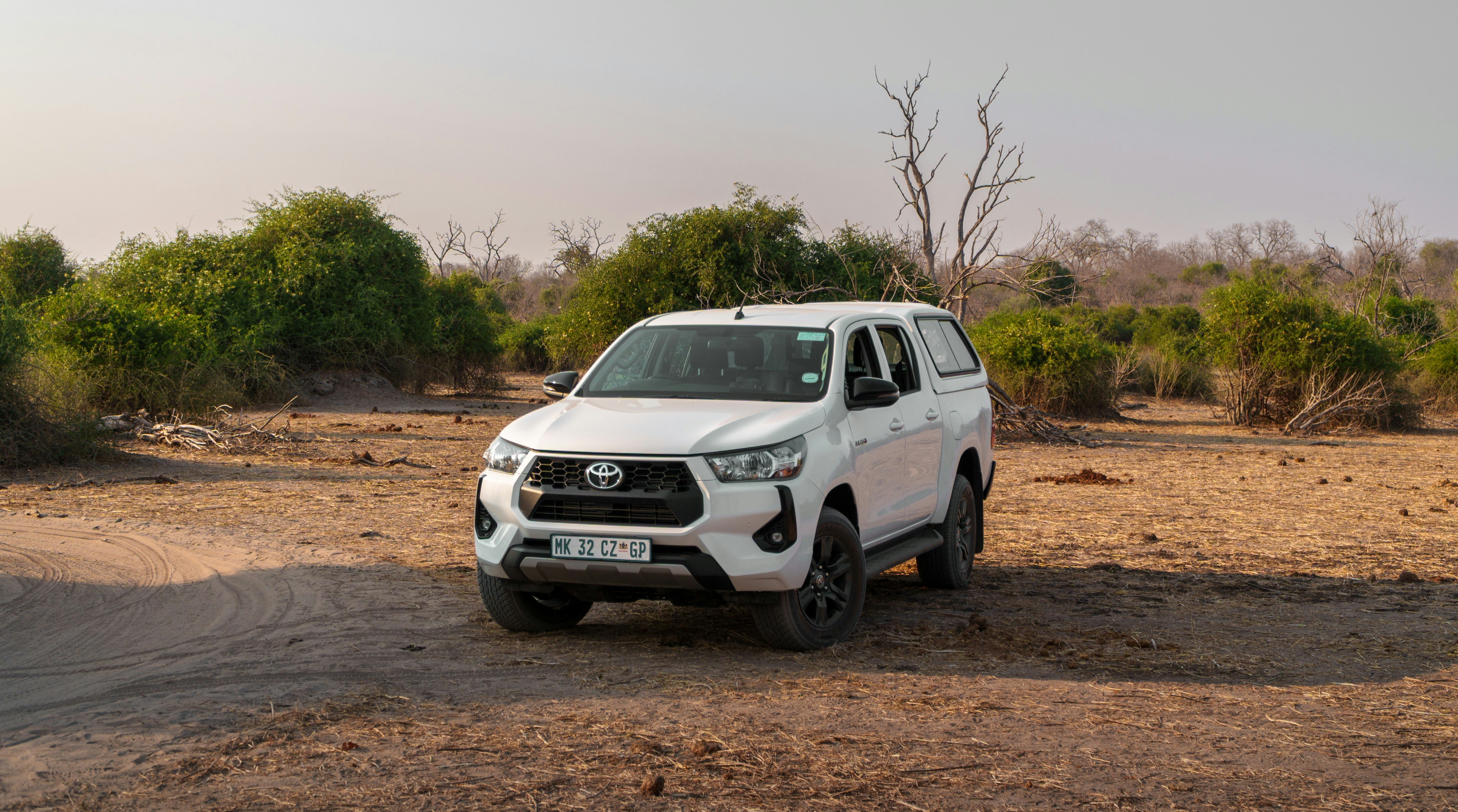 A Toyota SUV parked on a rugged terrain surrounded by sparse vegetation, showcasing its readiness for exploration.