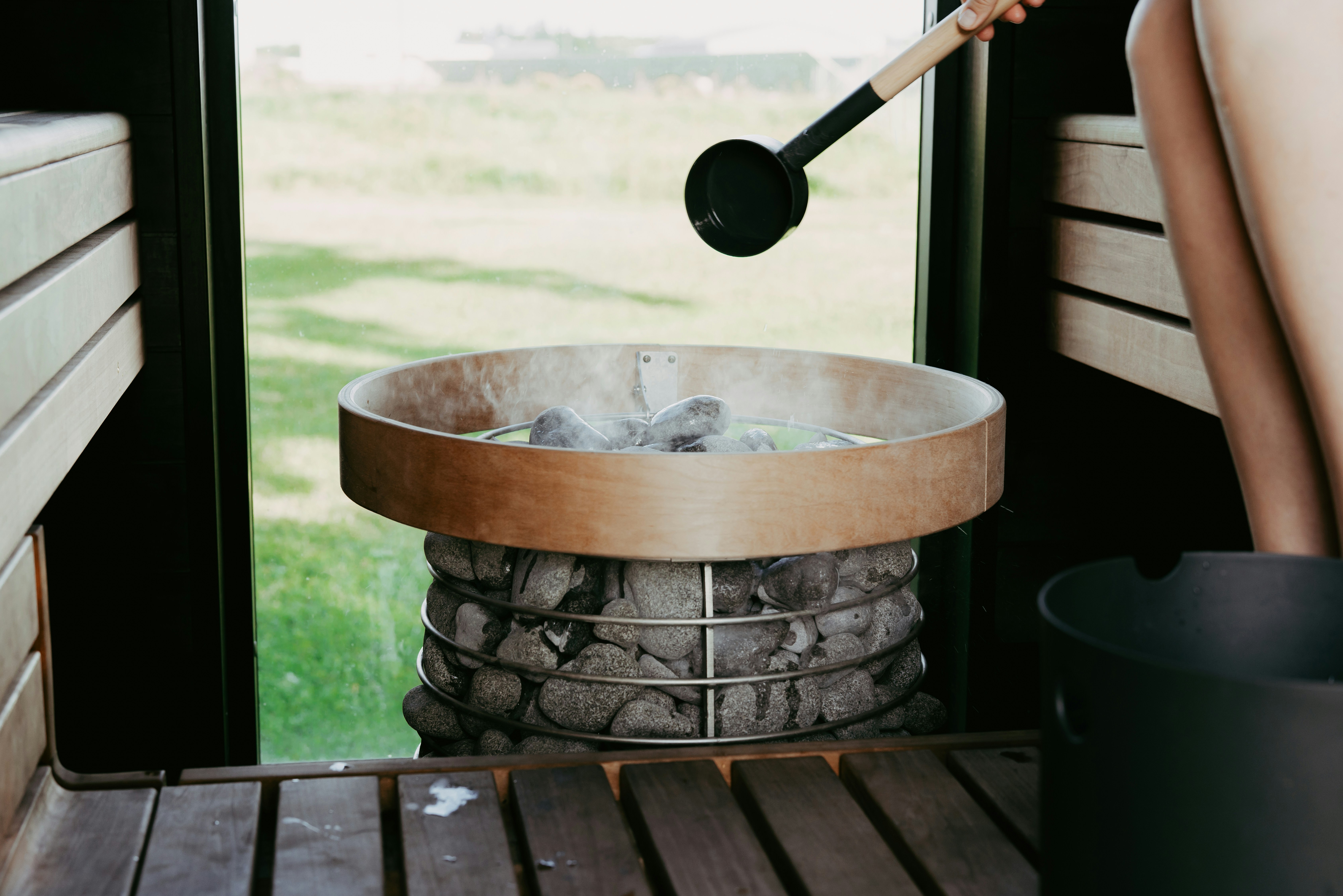 Pouring water onto hot stones in a sauna.