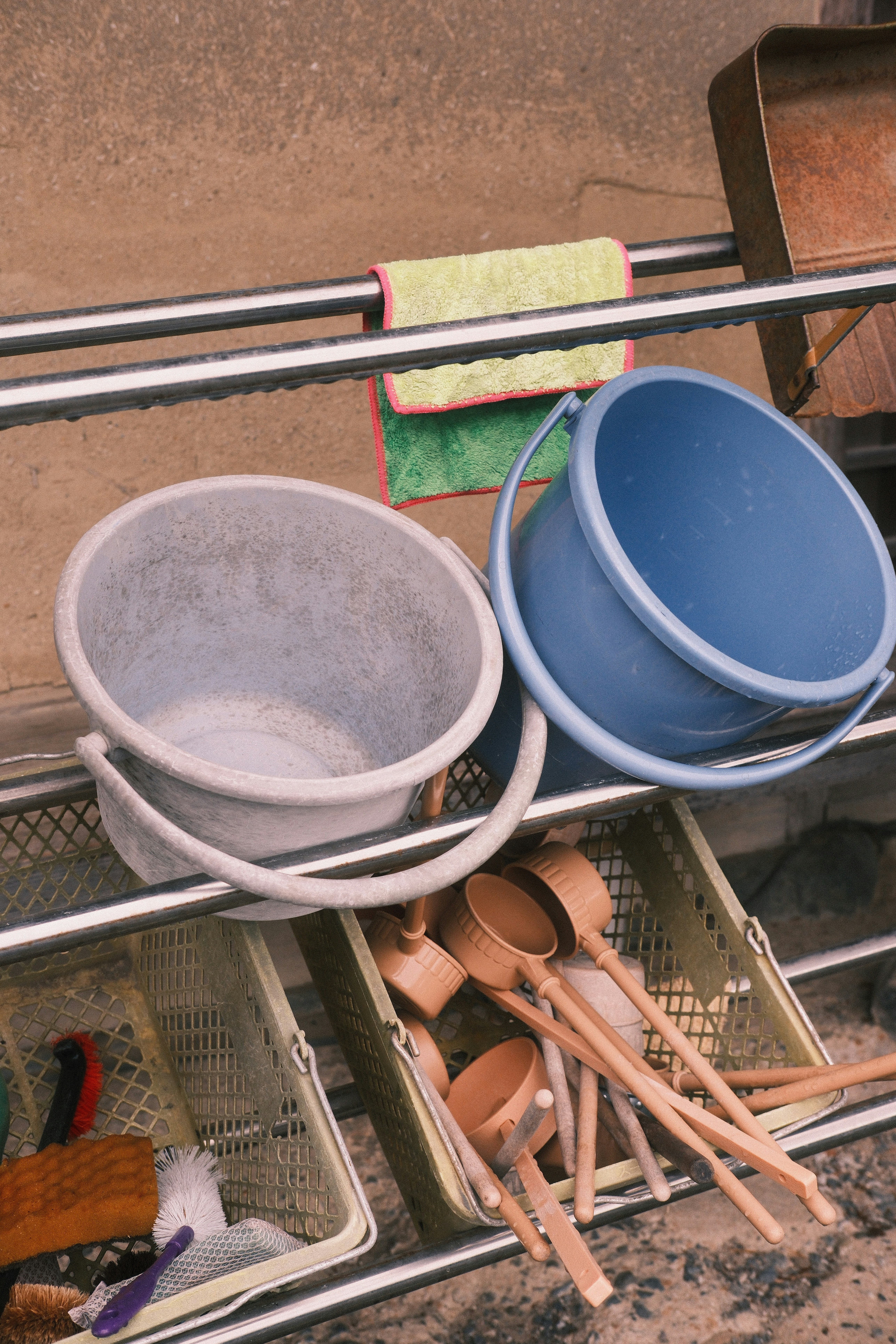 bucket. | Two buckets and ladles on a rack