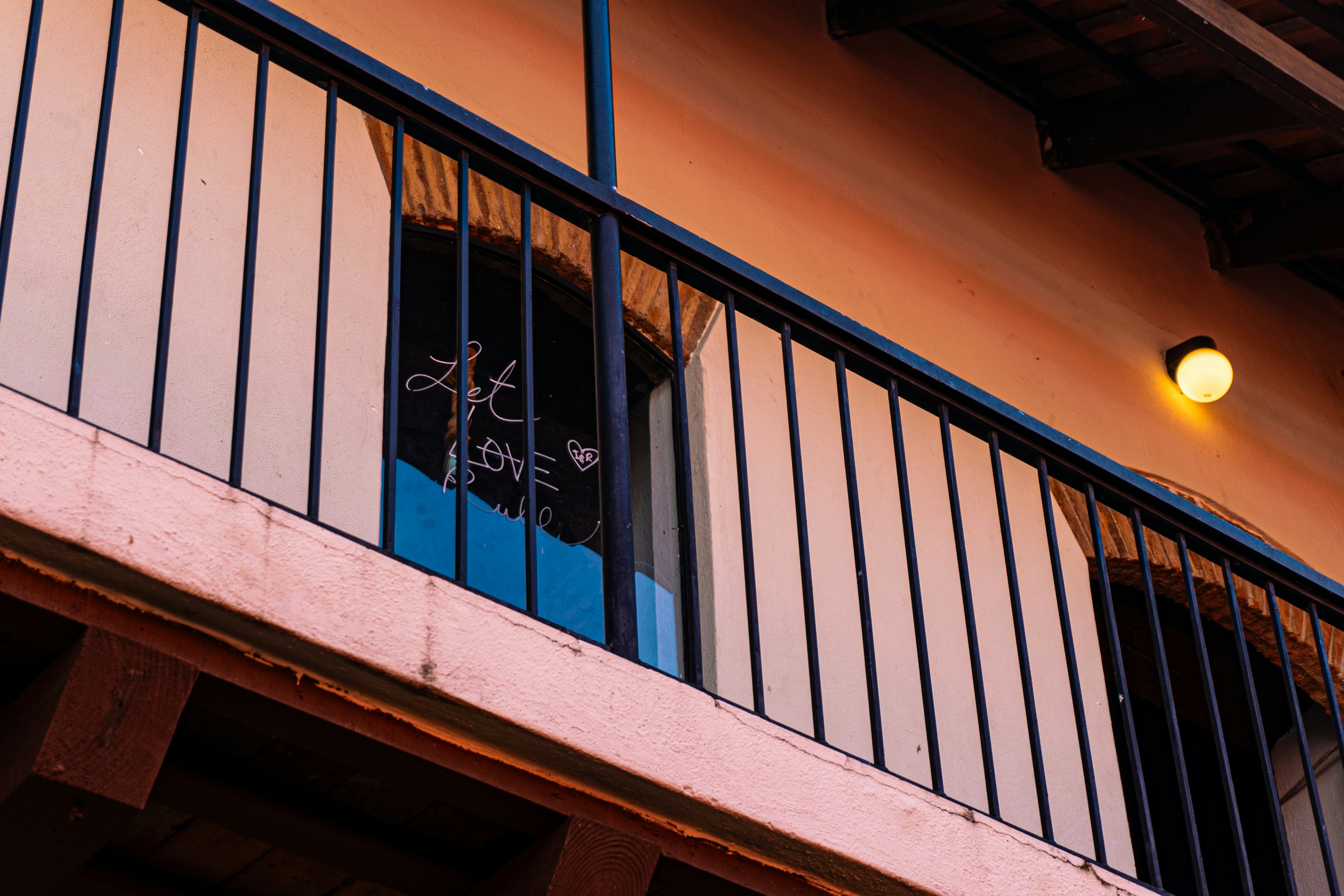 Blue Door Behind a Guardrail: A Quiet Balcony Moment