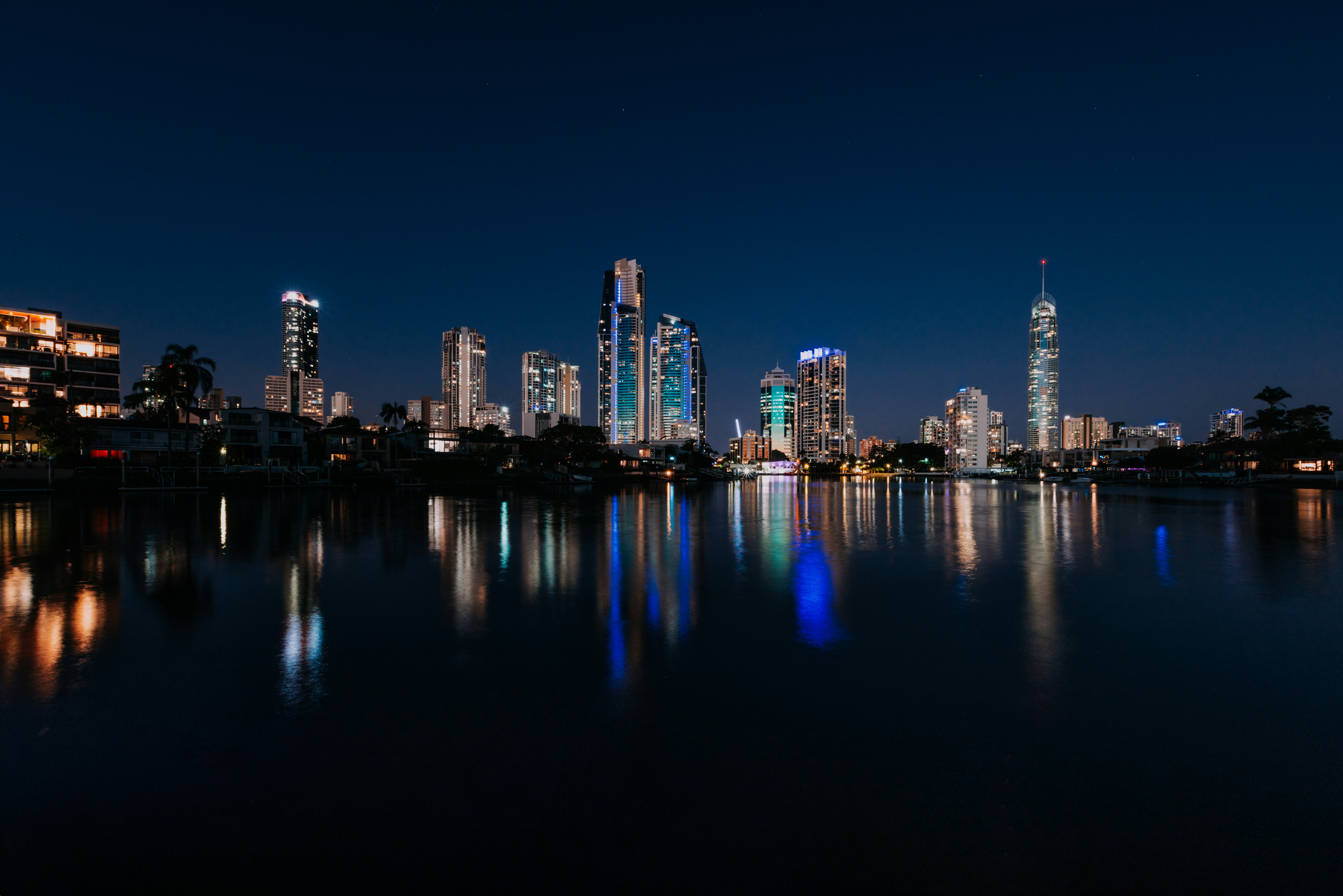 Gold Coast city skyline at night from Chevron Island | City skyline illuminated at night with reflections on water.