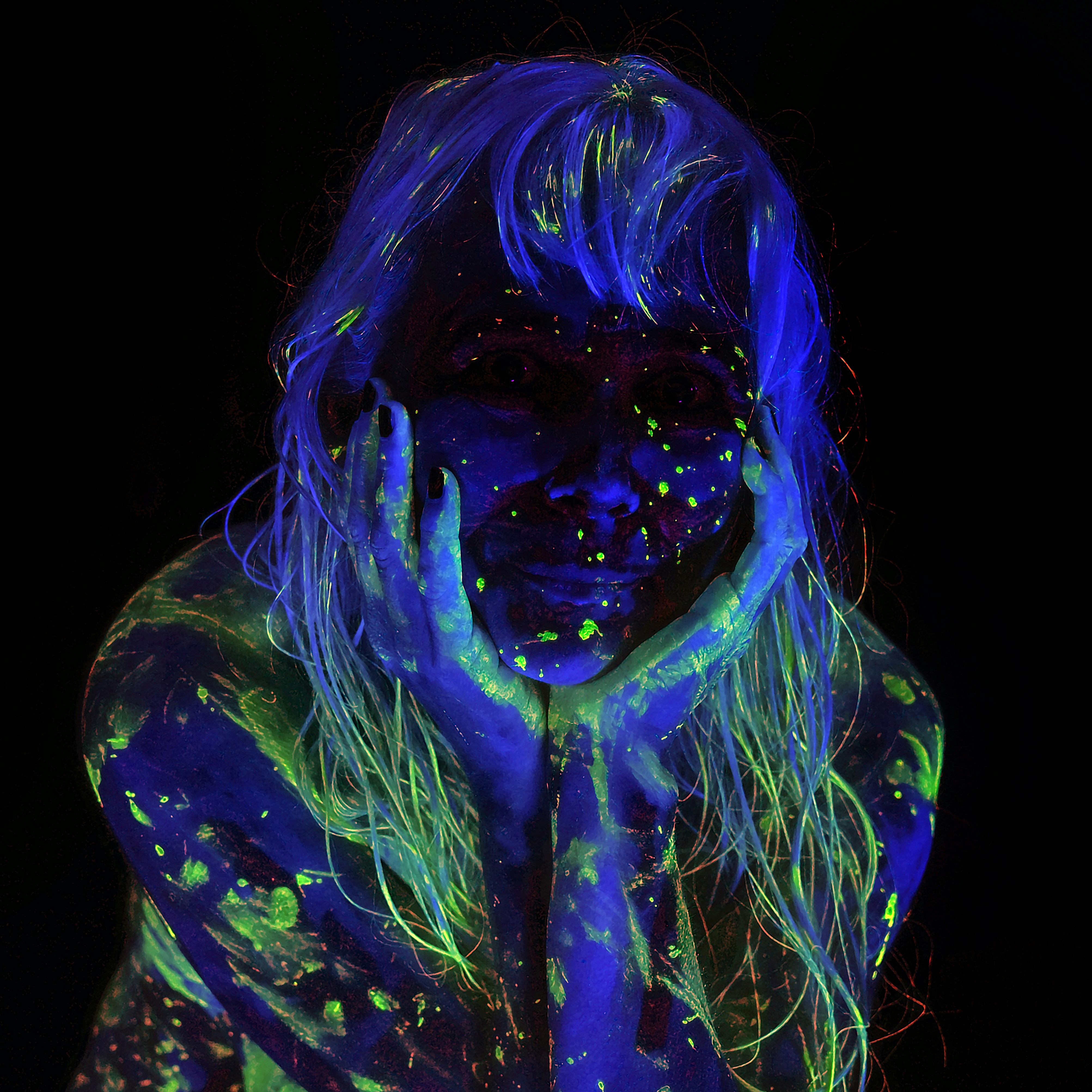 Woman with neon paint on face and hair