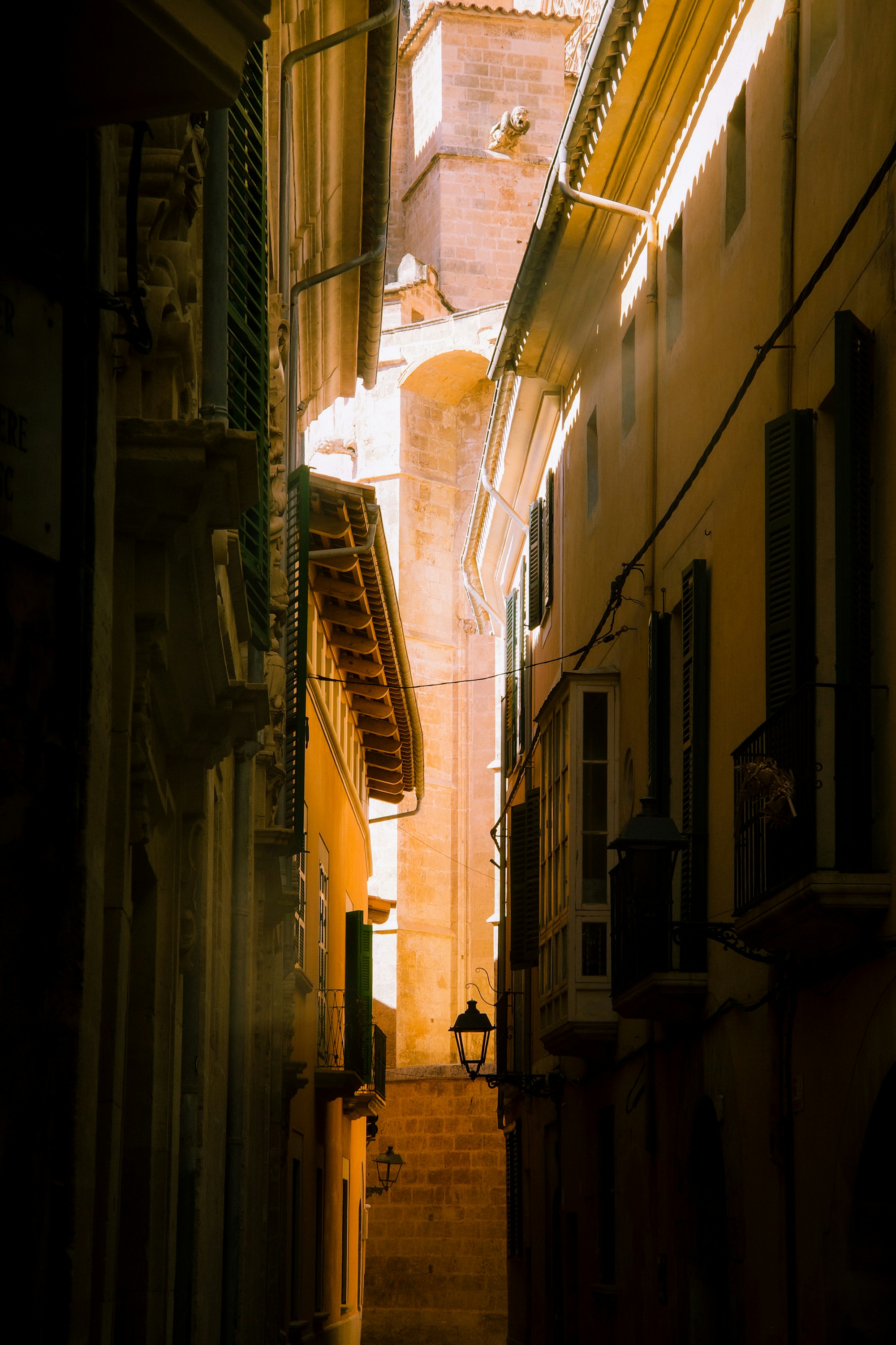 Narrow european street with a distant church tower.
