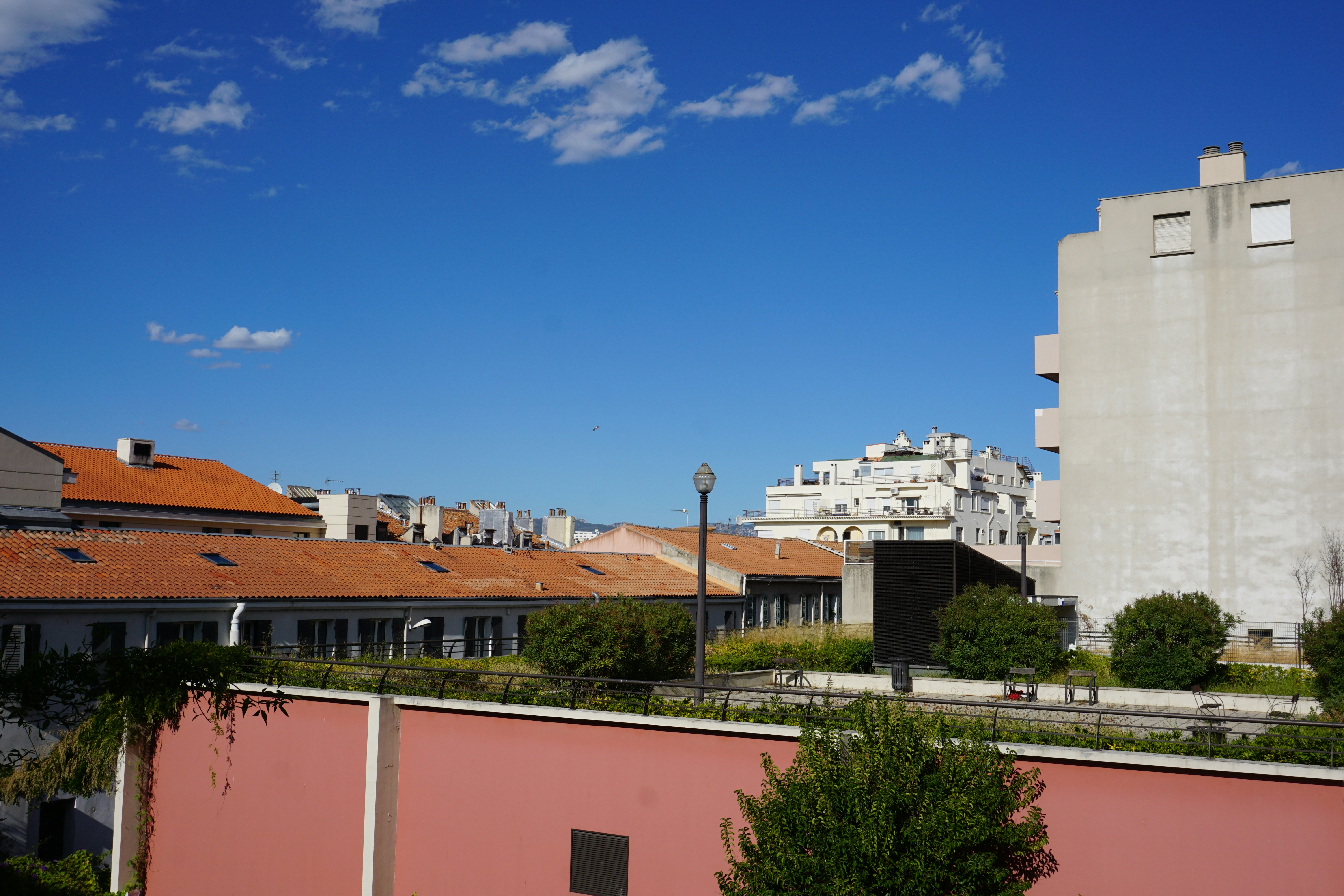 Buildings under a clear blue sky with clouds.