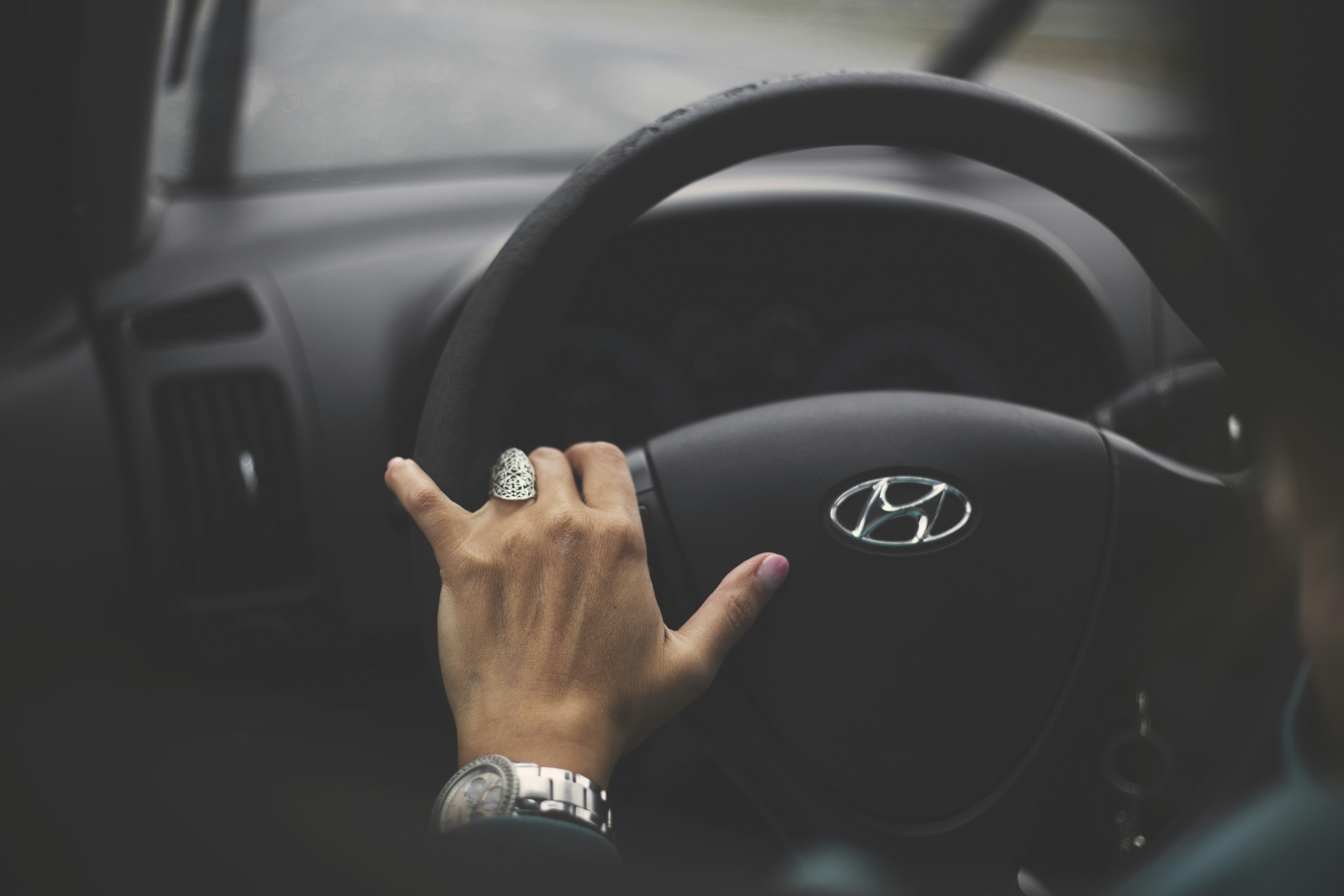 Hand on steering wheel inside car