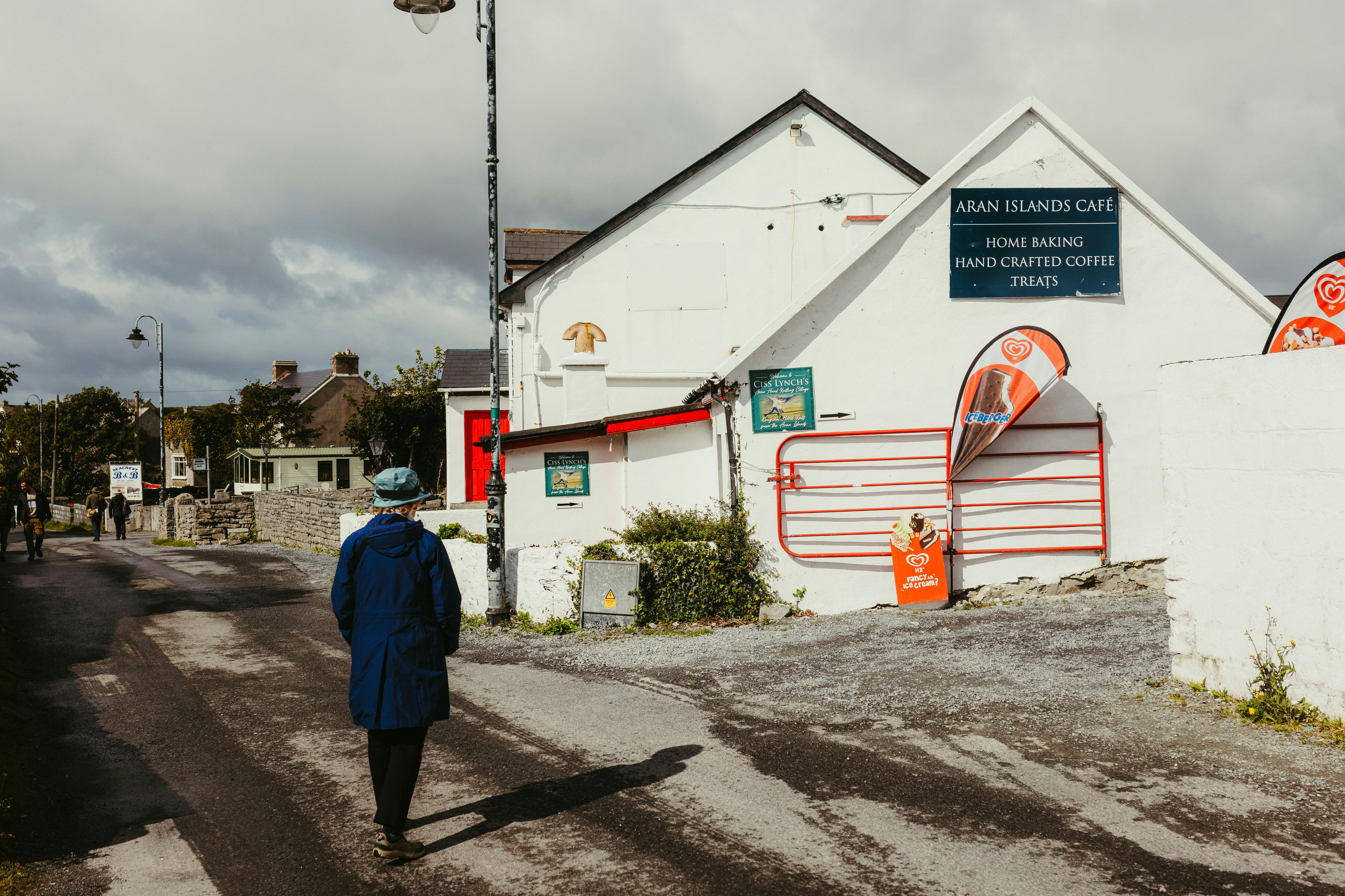 Lone Walker on a Quiet Aran Street Toward the White Café