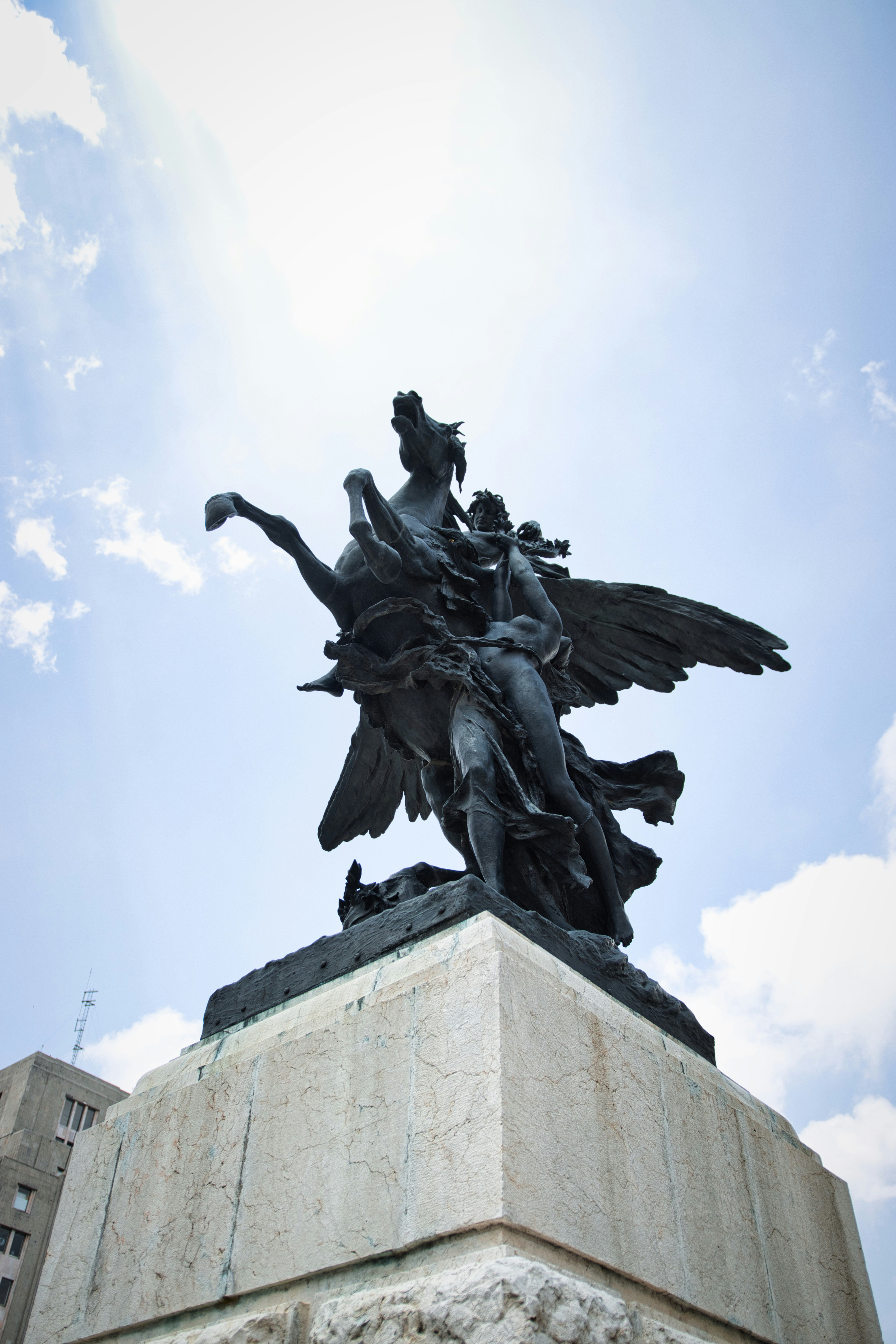 Winged sculpture of figures on a horse pedestal.