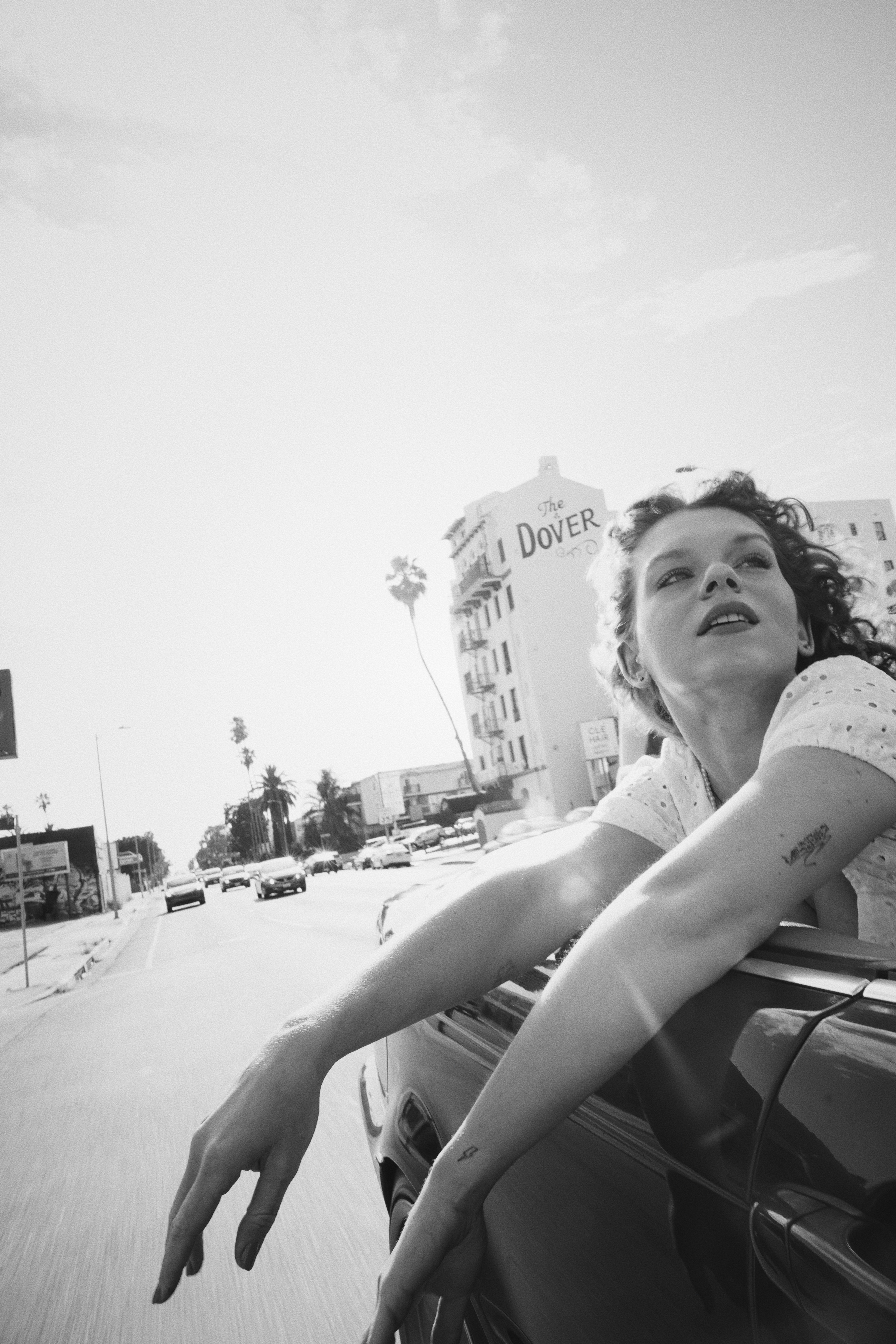Rolling Days | Woman leaning out of car window on sunny day.