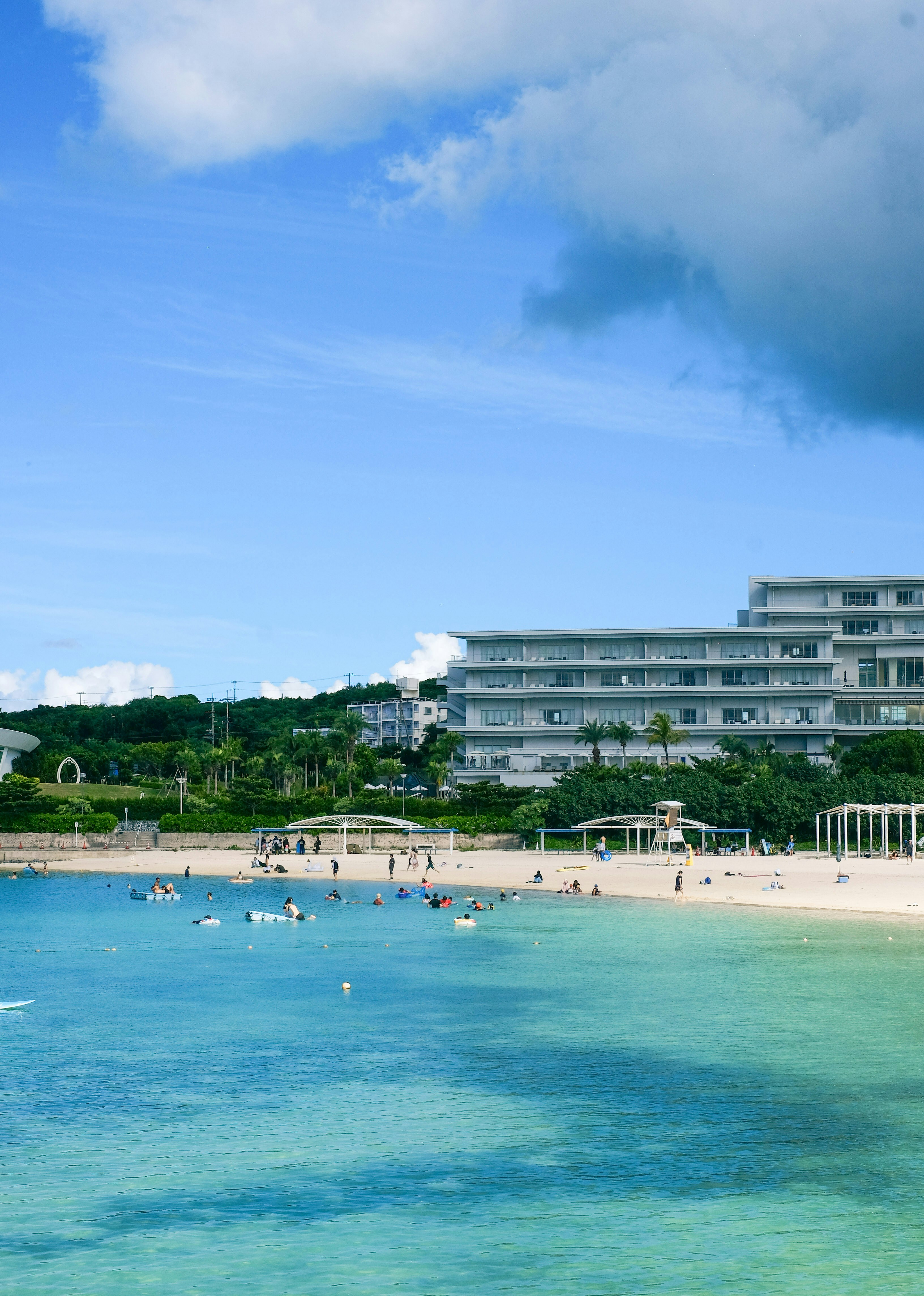 Shoreline Echo: Sunlit Beach Beneath a Quiet Modern Hotel
