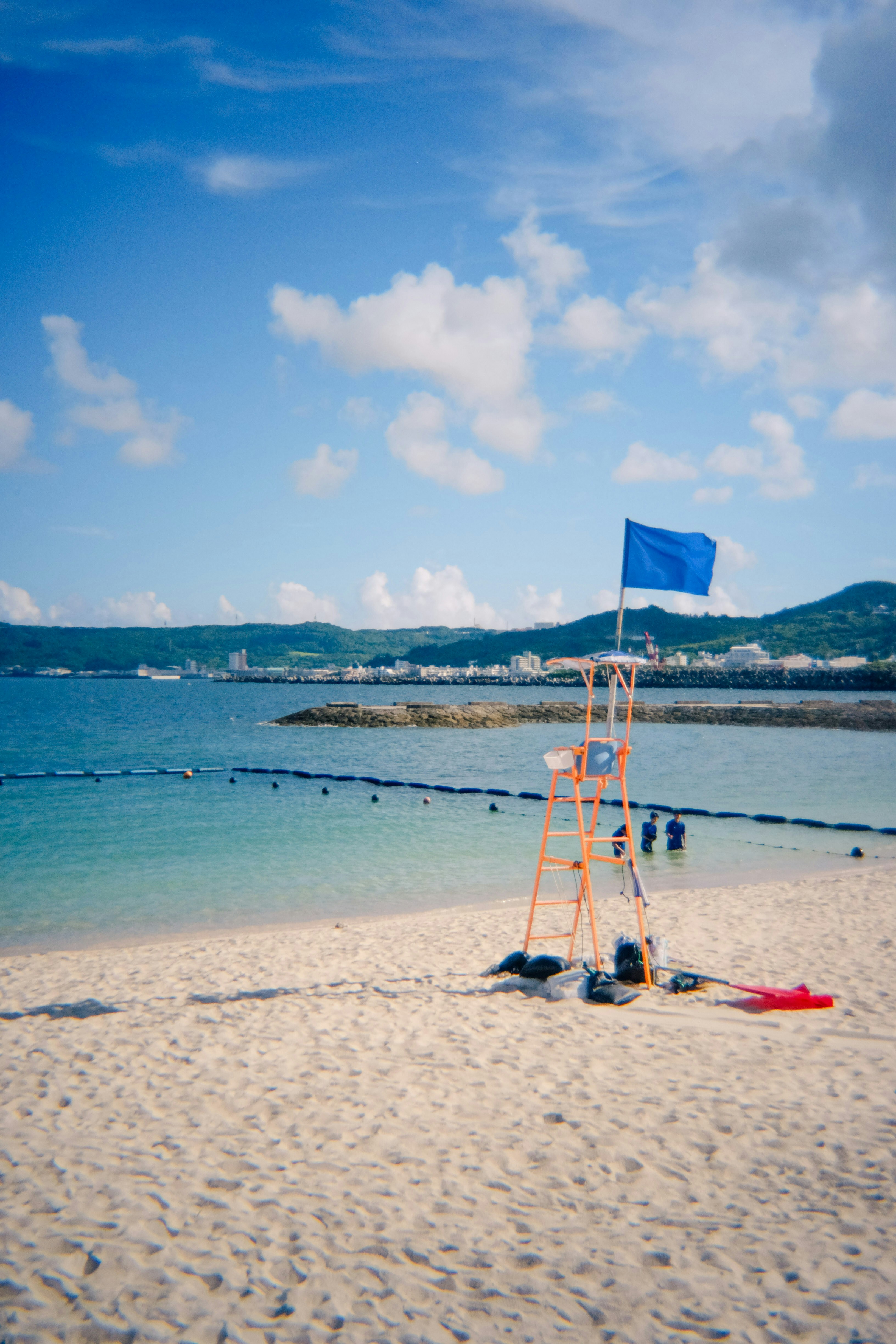 Blue Flag Above an Orange Lifeguard Chair: A Quiet Coastal Moment