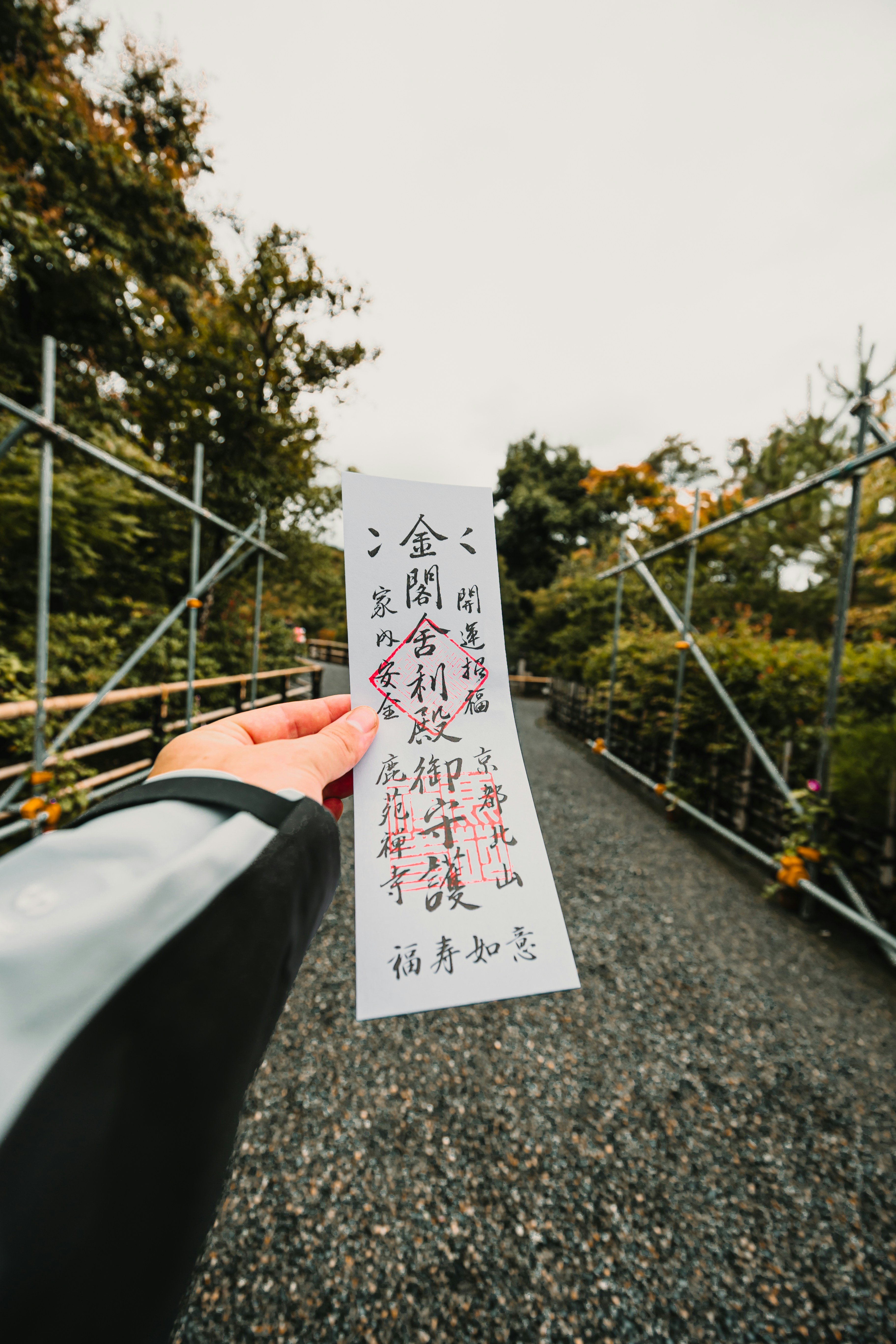 Hand holding japanese paper with calligraphy
