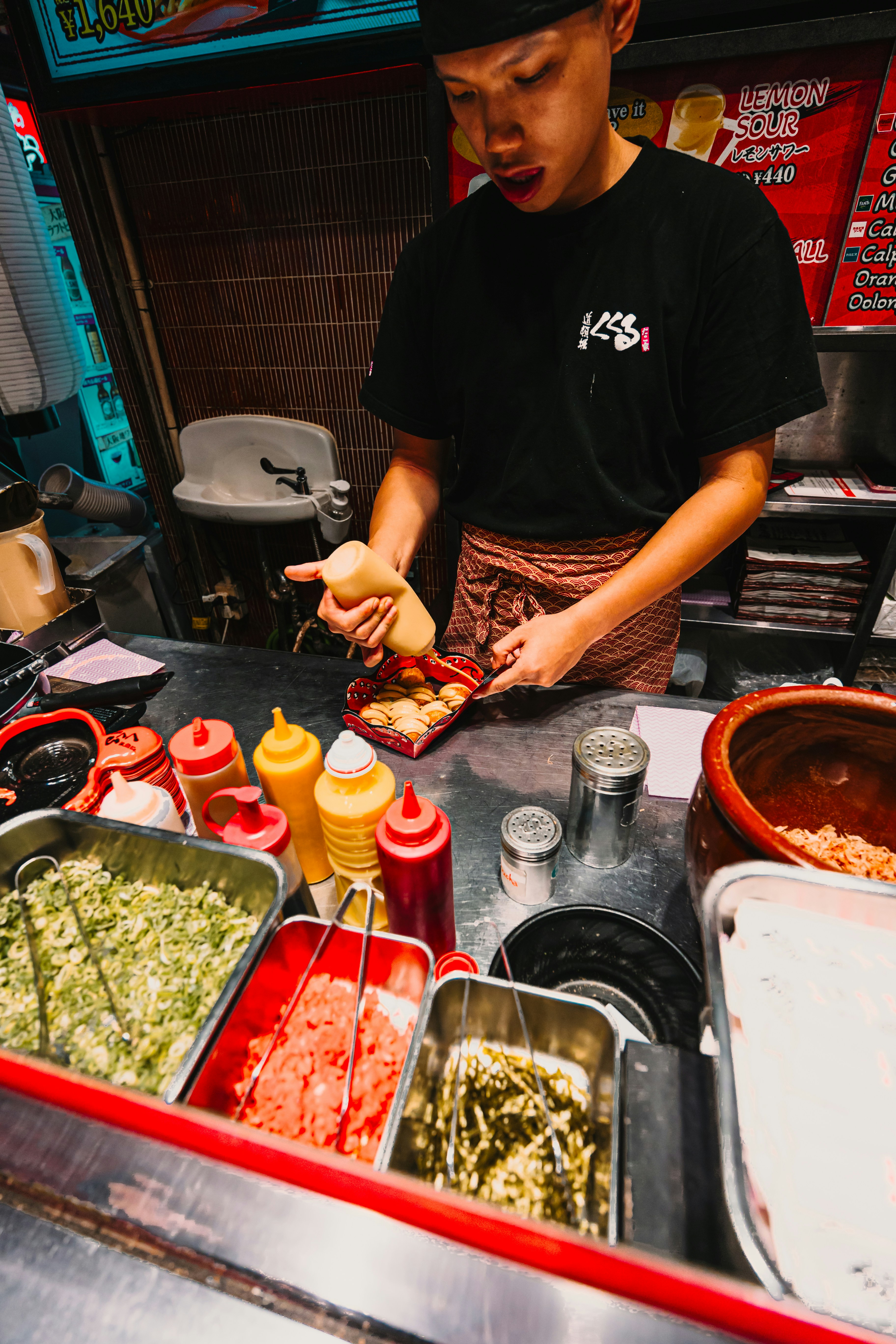 A person preparing food at a street food stall.