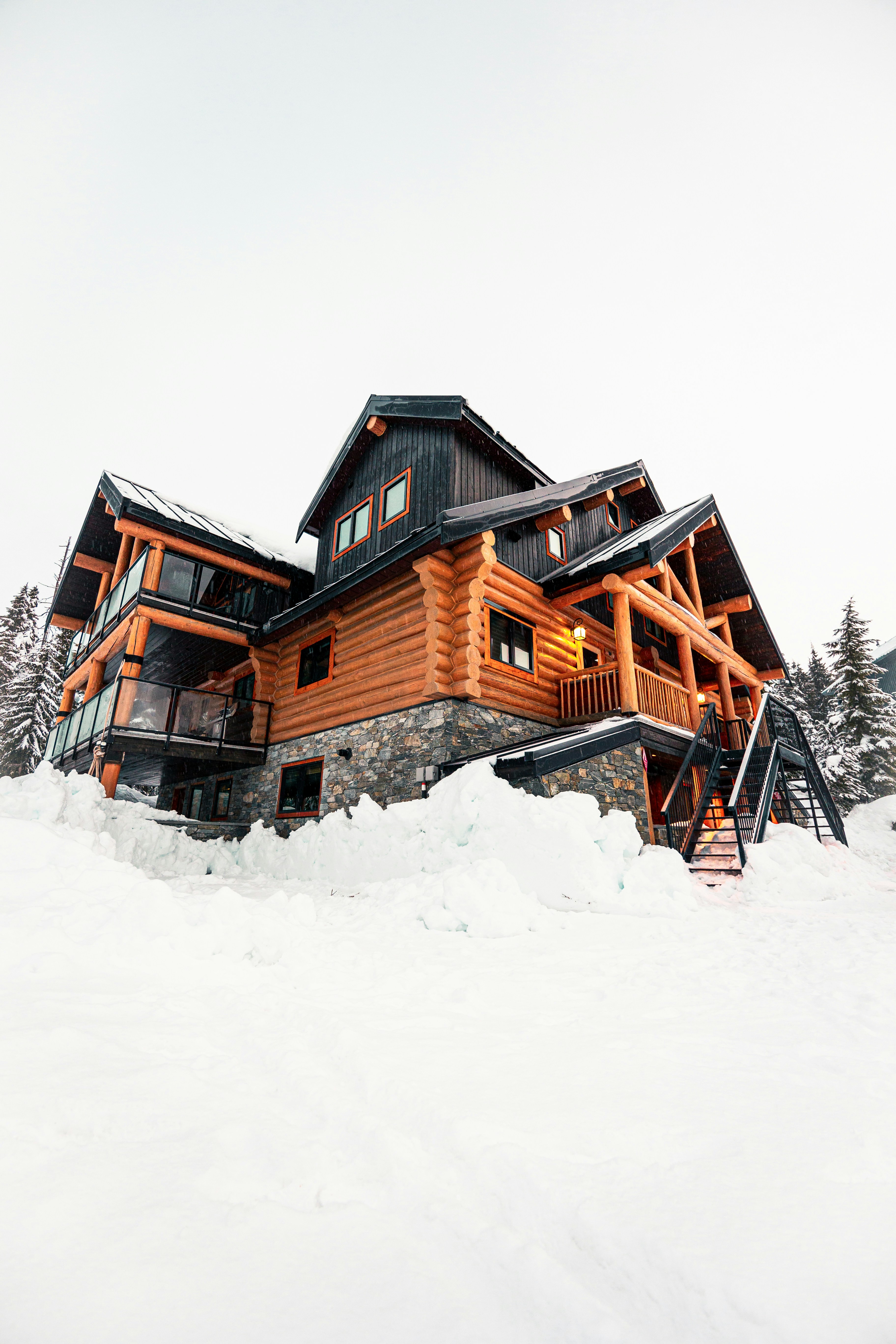 Modern log cabin nestled in a snowy landscape, showcasing a blend of rustic charm and contemporary design.