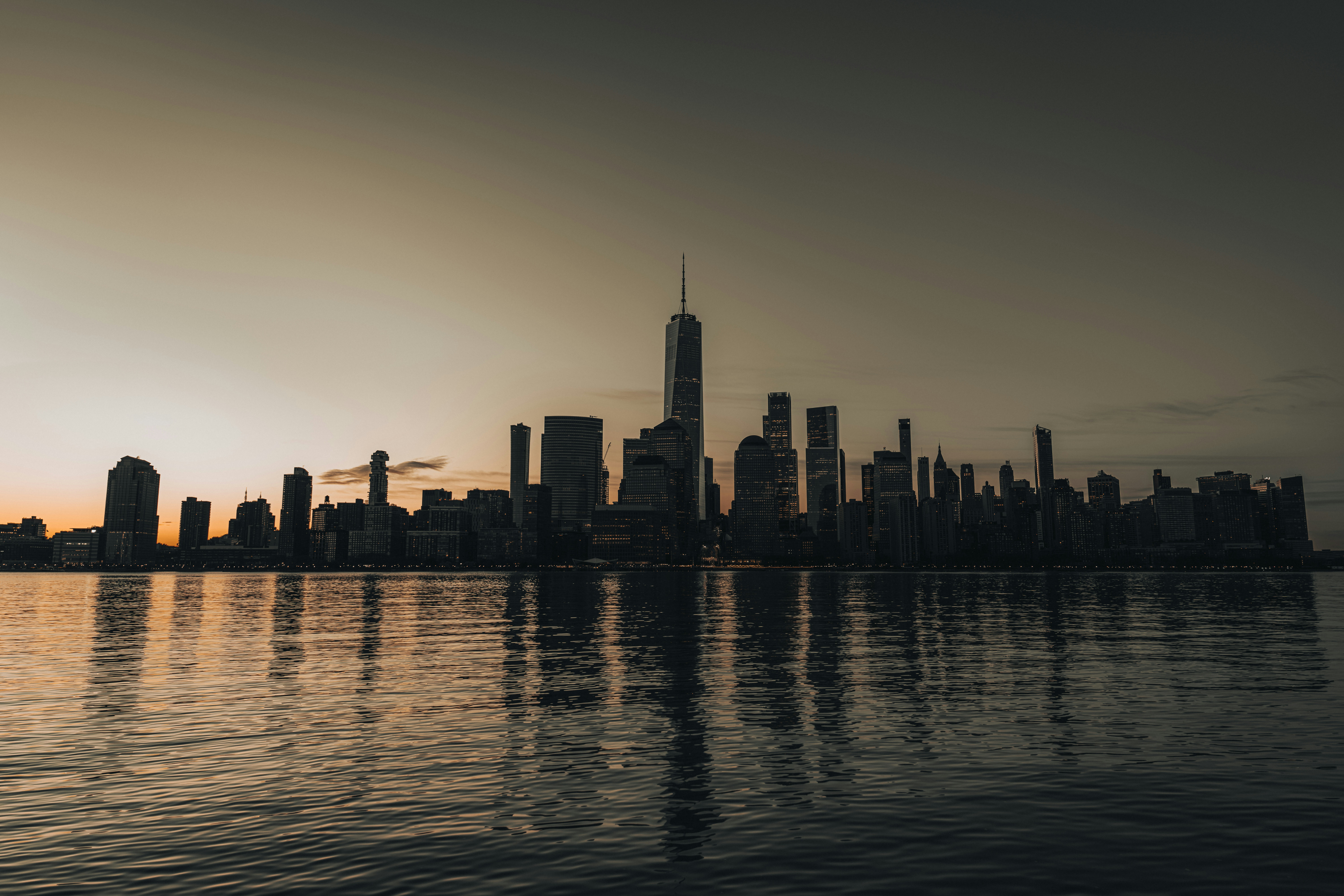 City skyline reflected in calm water at sunset