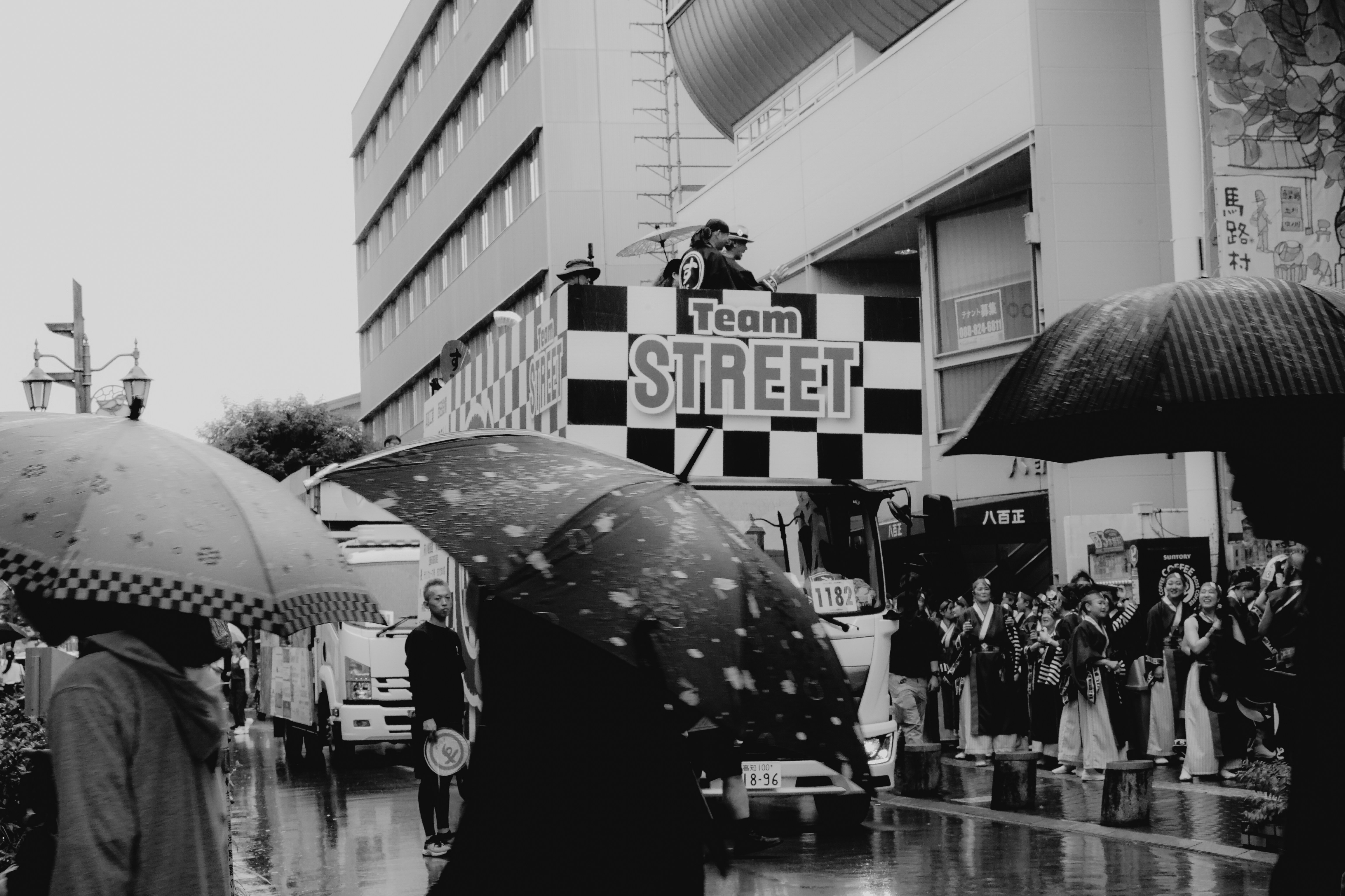 Rain-Slicked Rally: Team Street Banner Over a Crowded Parade