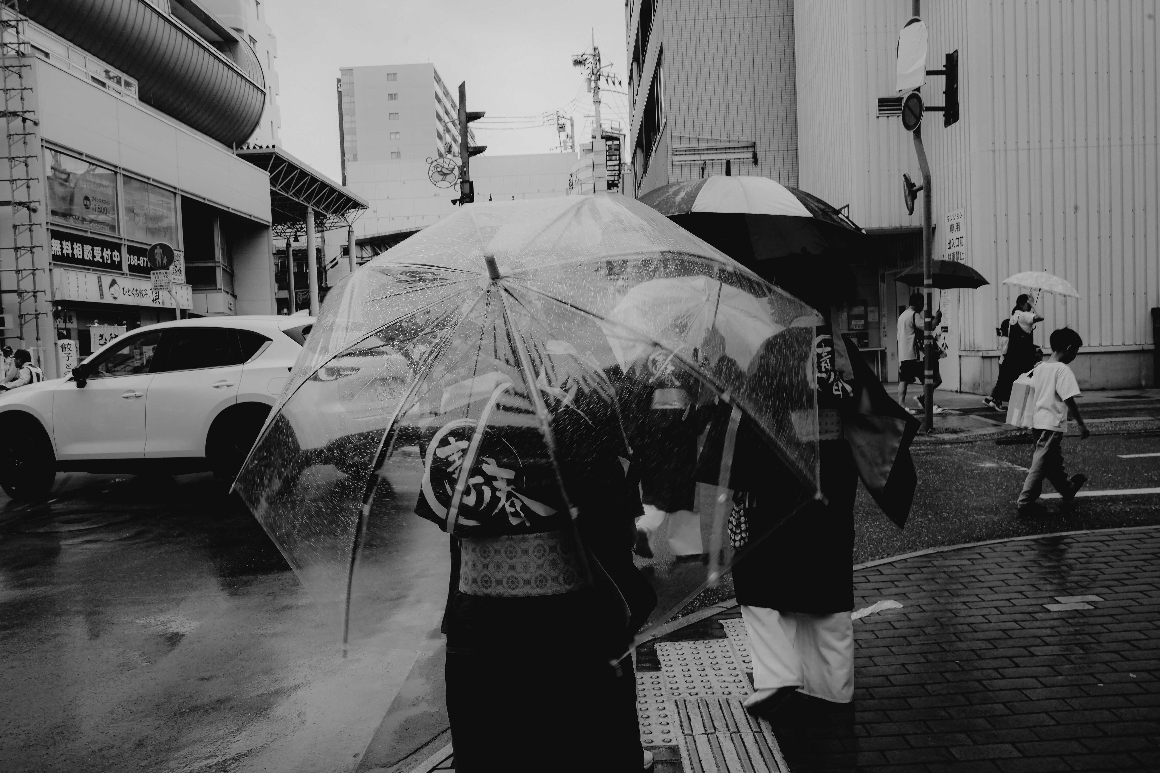People with umbrellas on a rainy city street.