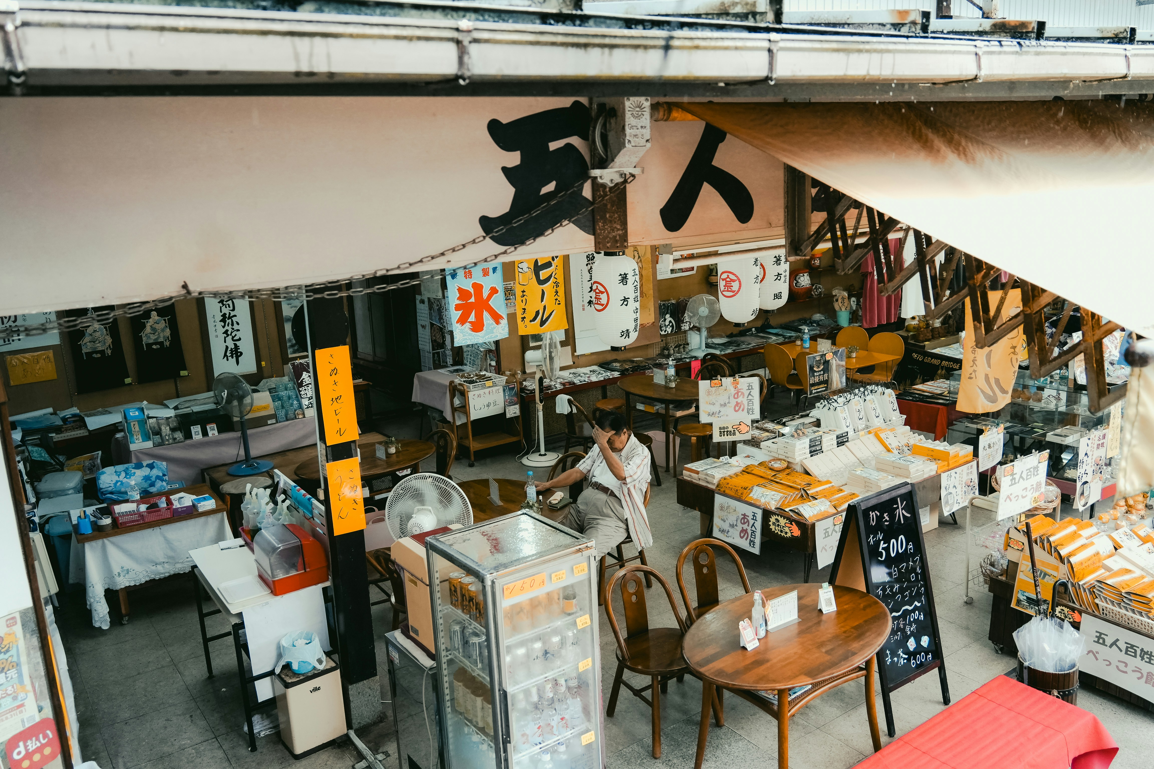 Japanese market stall with various goods and signage