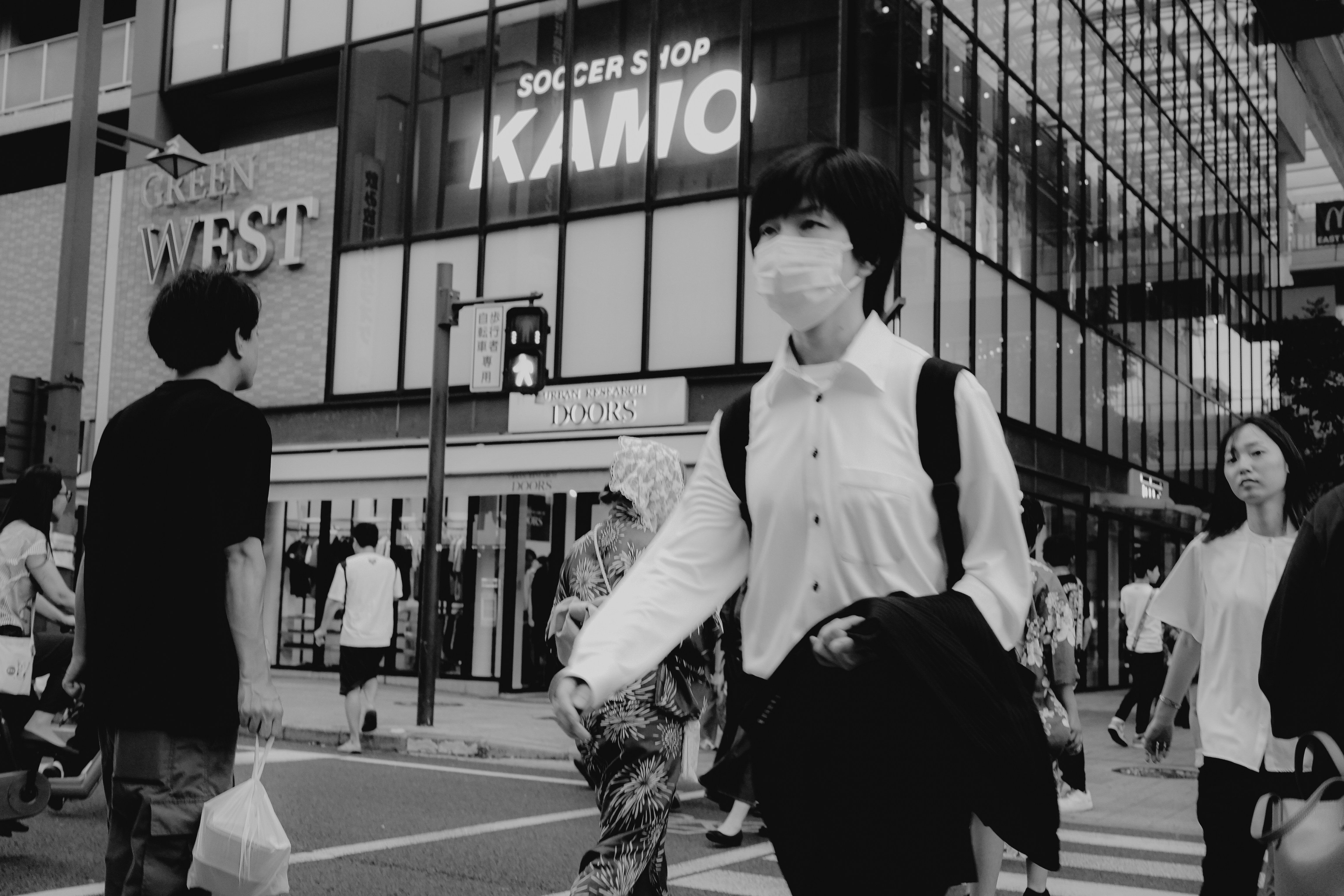 Monochrome Crosswalk: The White-Shirted Figure Amid Urban Flow