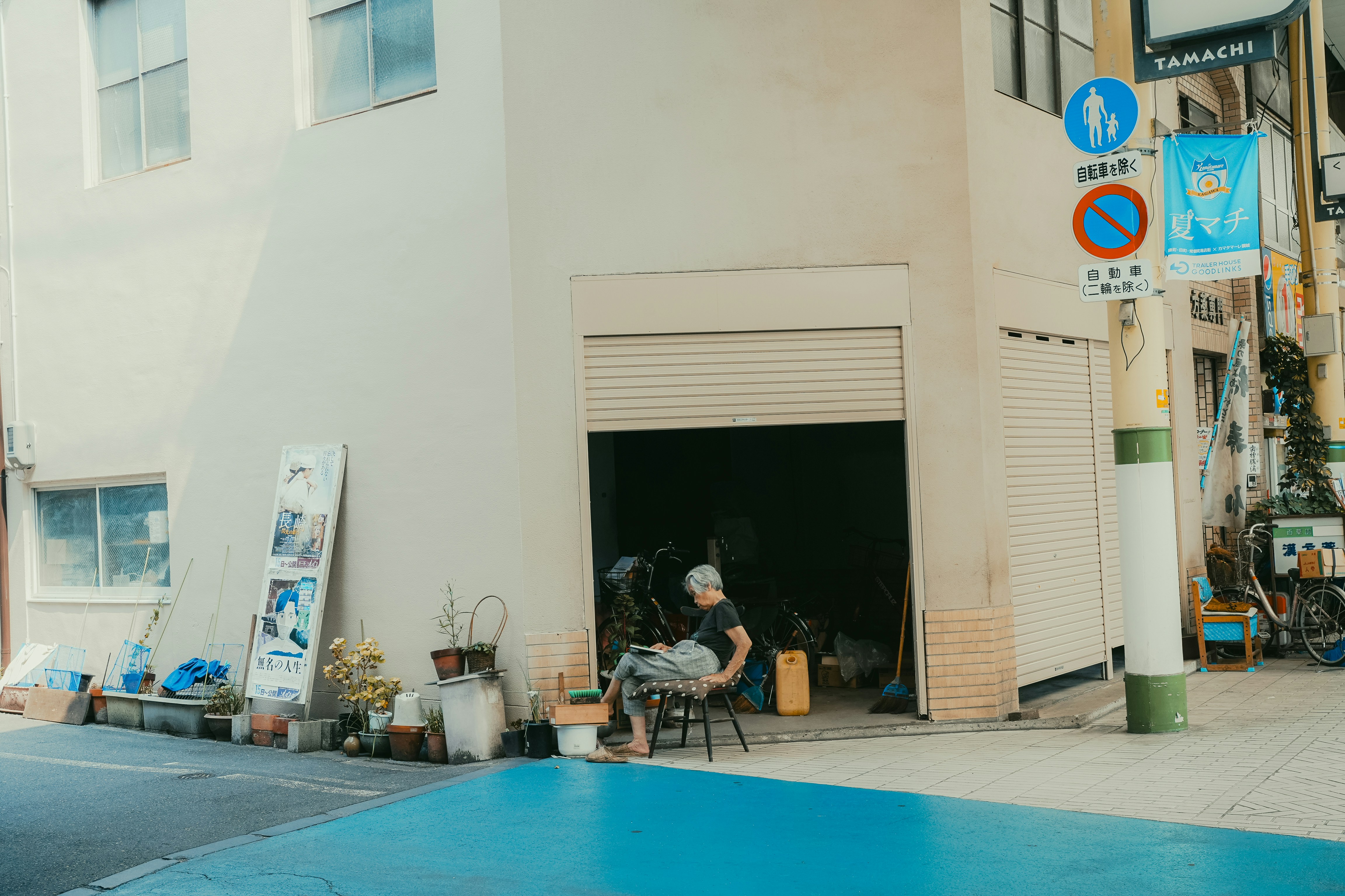 Person sitting outside a building with closed garage door. photo – Free ...