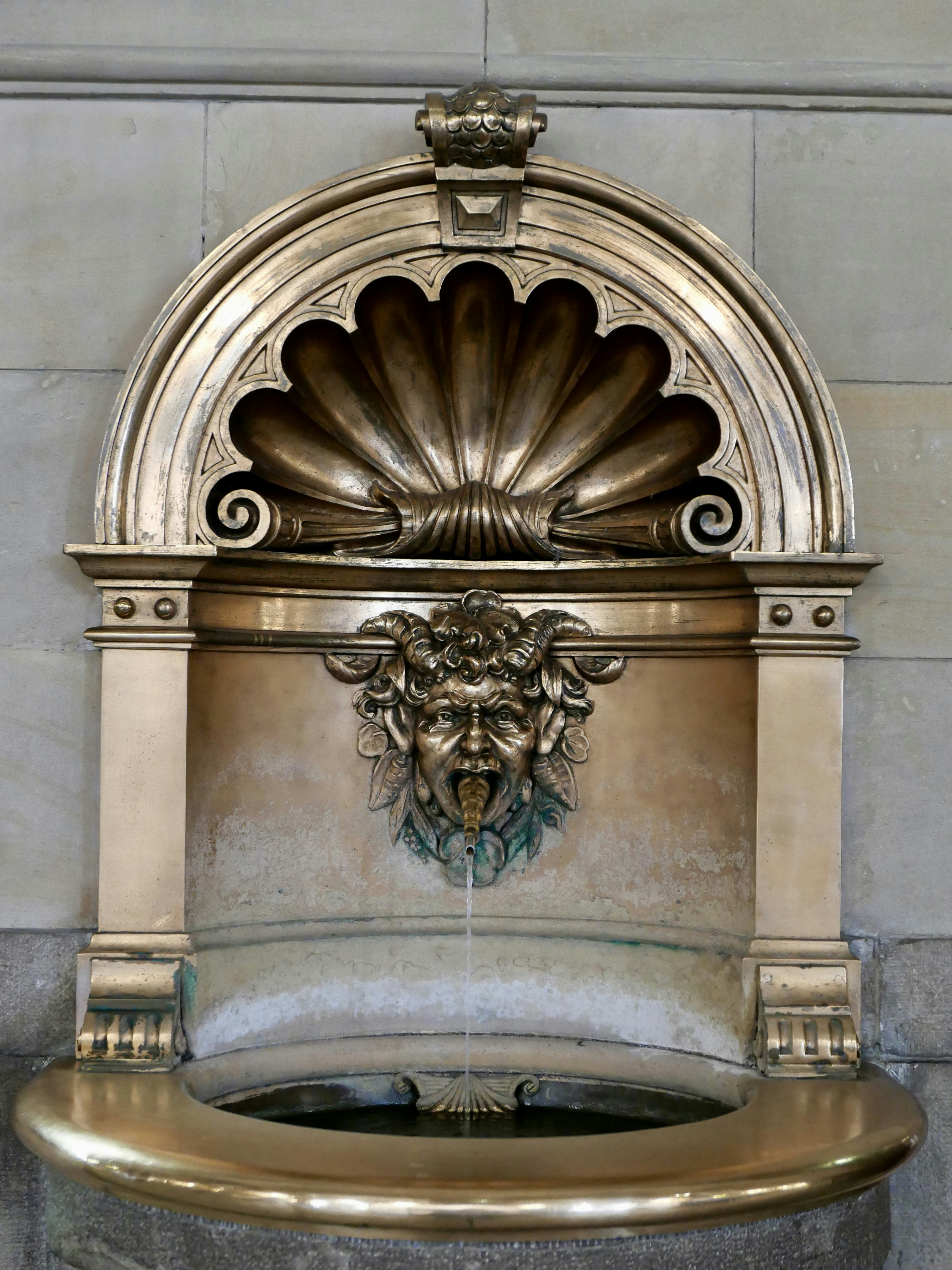 Ornate bronze fountain with a grotesque face