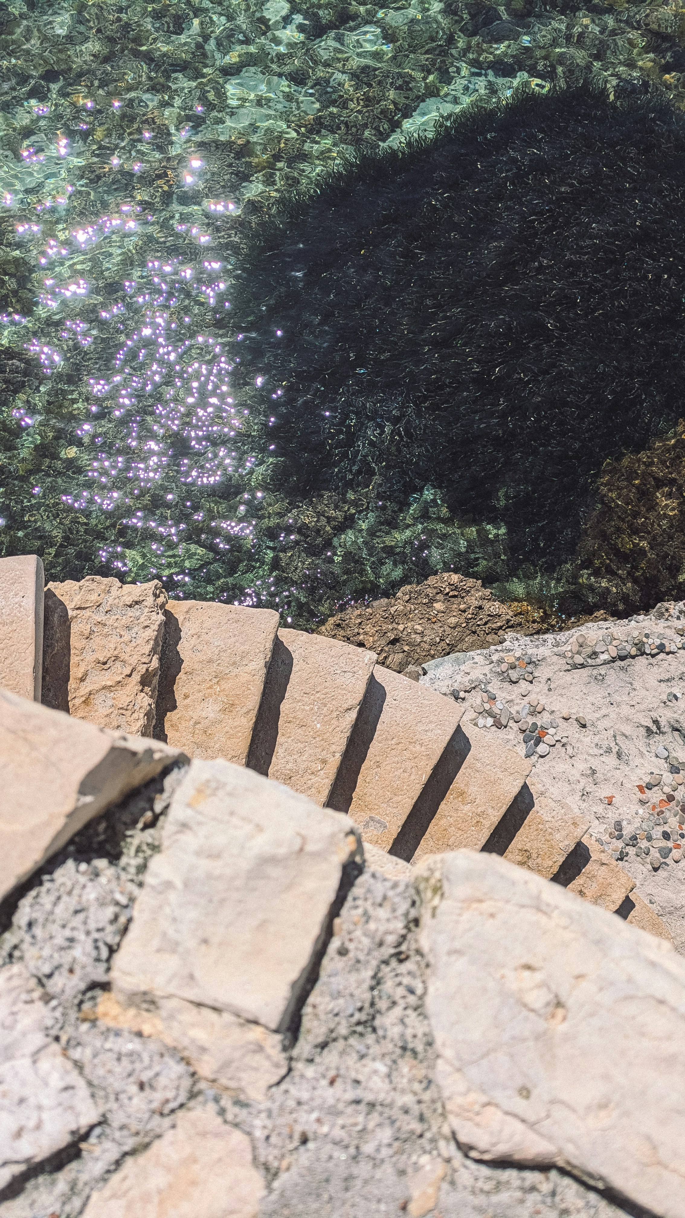 Stone steps lead down to clear ocean water