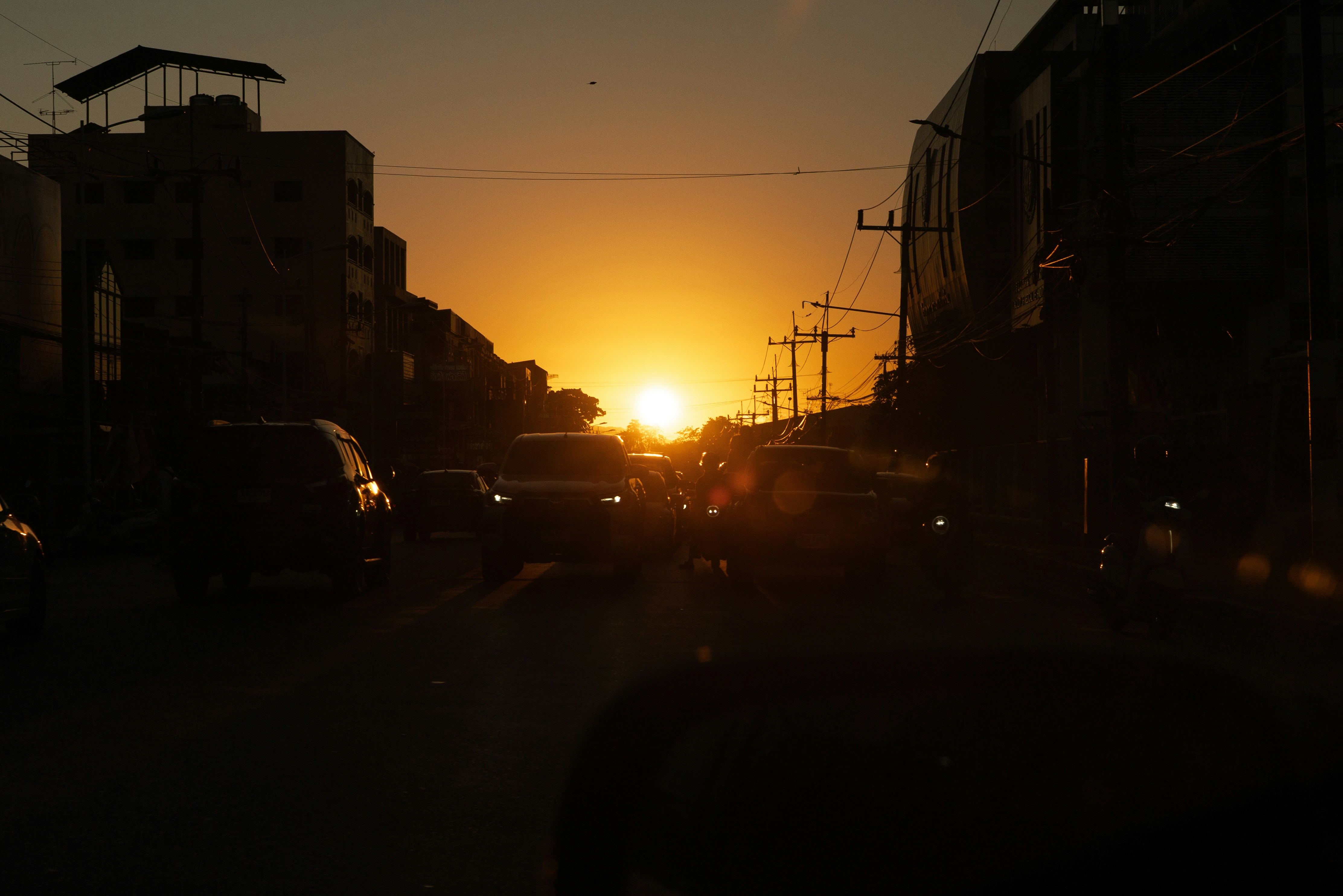 Sunset over a city street with cars.
