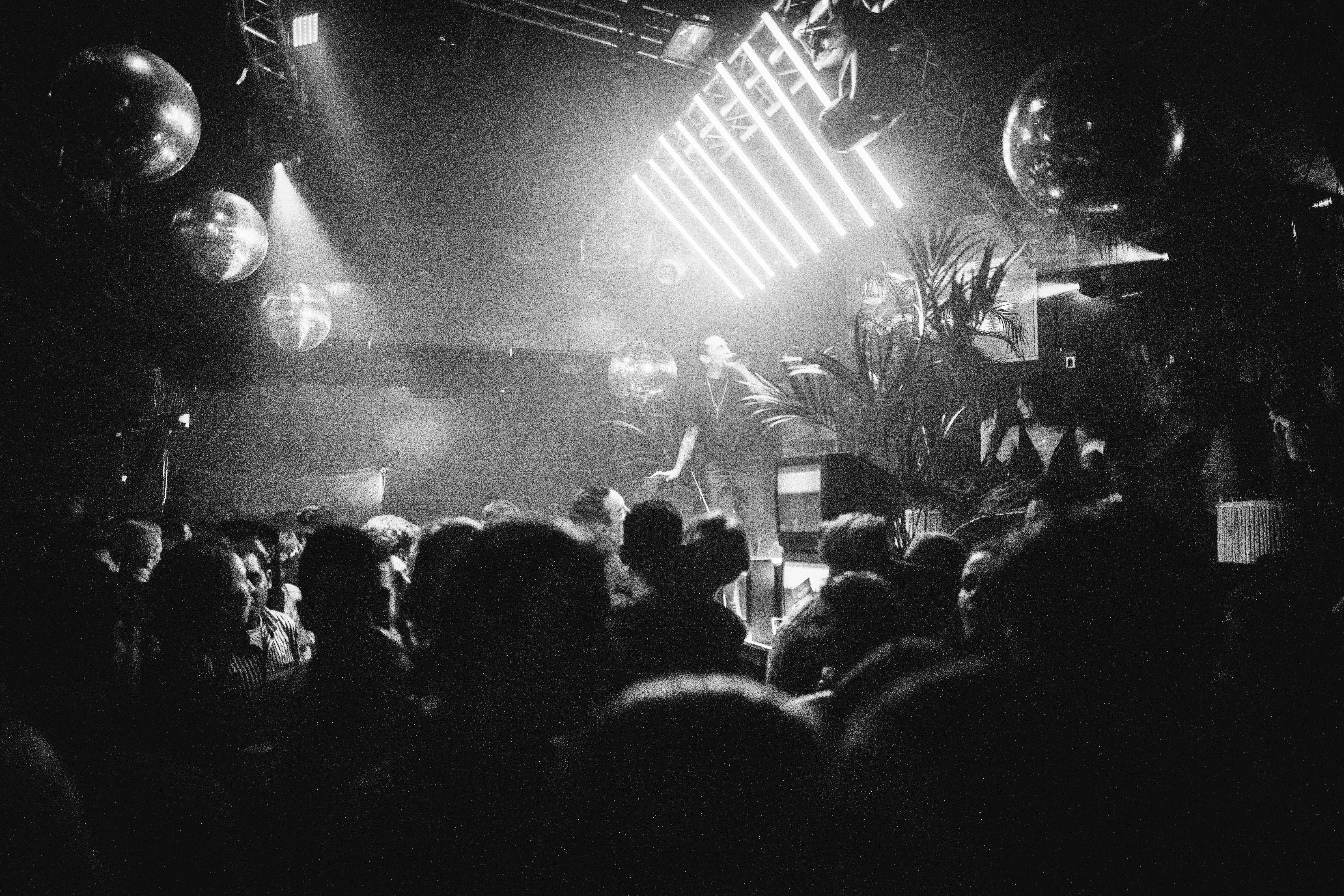 Dynamic dance floor scene illuminated by neon lights and disco balls, capturing the vibrant energy of nightlife.