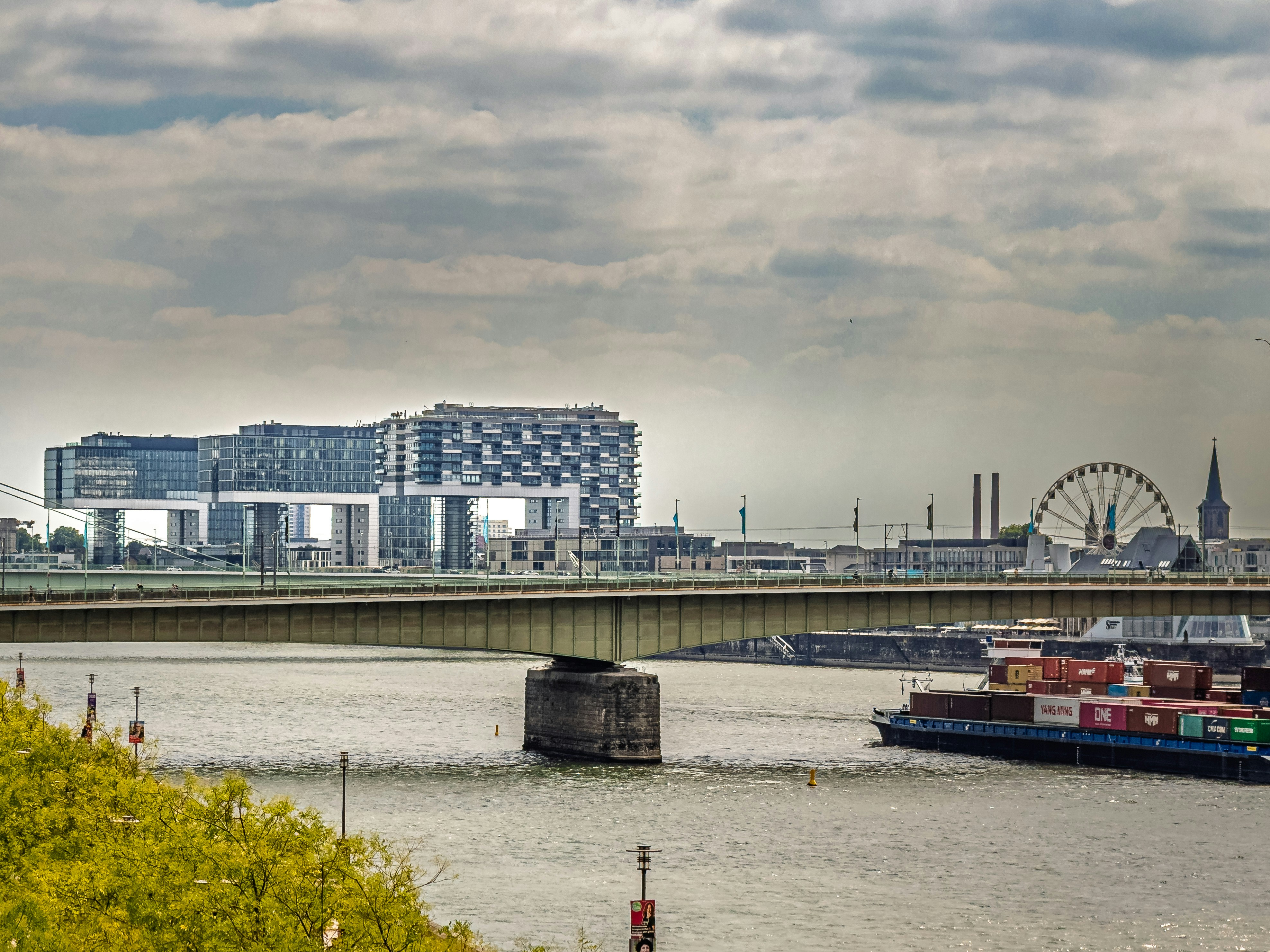 Modern buildings overlooking a wide river with cargo ship.
