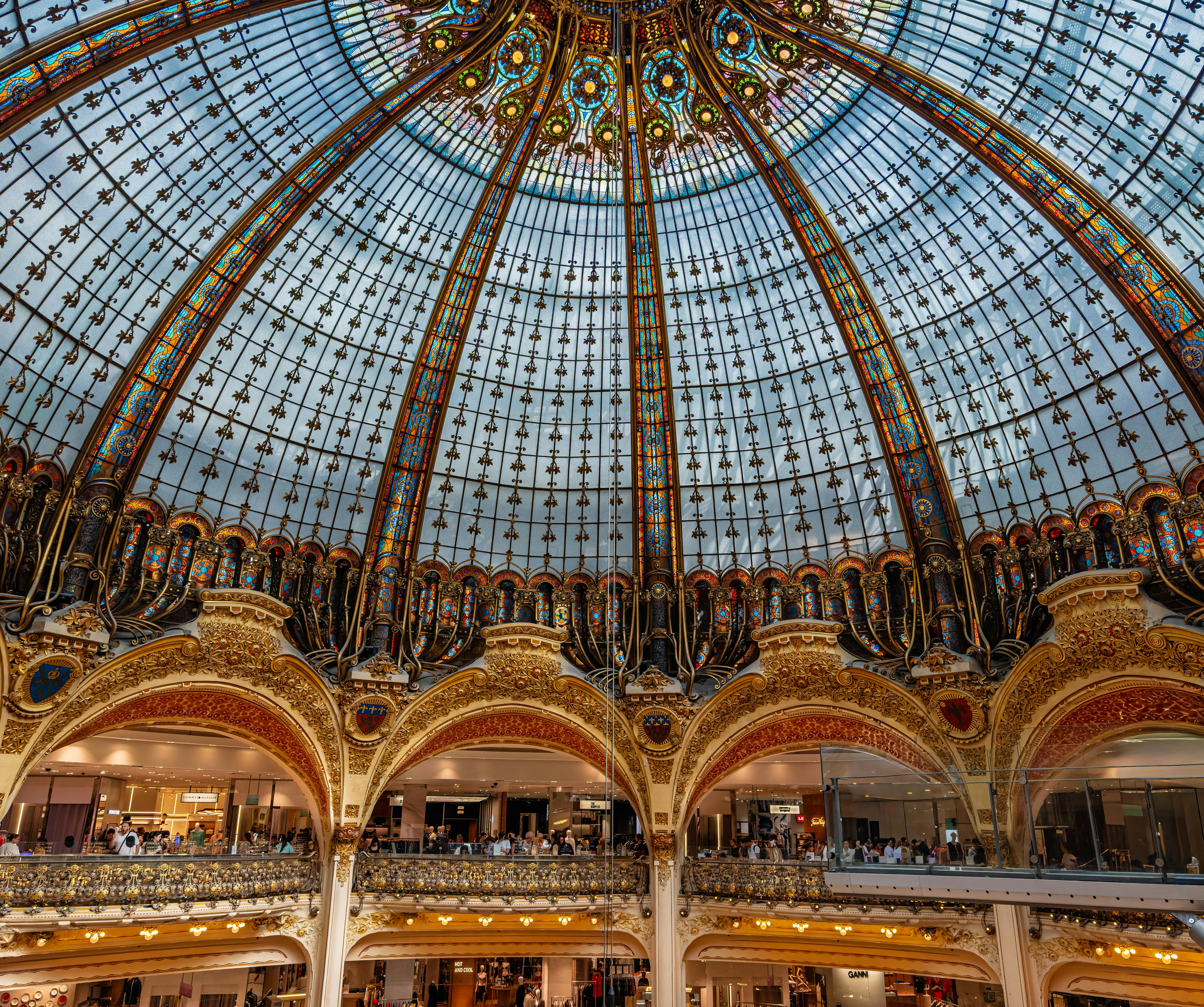 Ornate stained glass dome interior with balconies below.