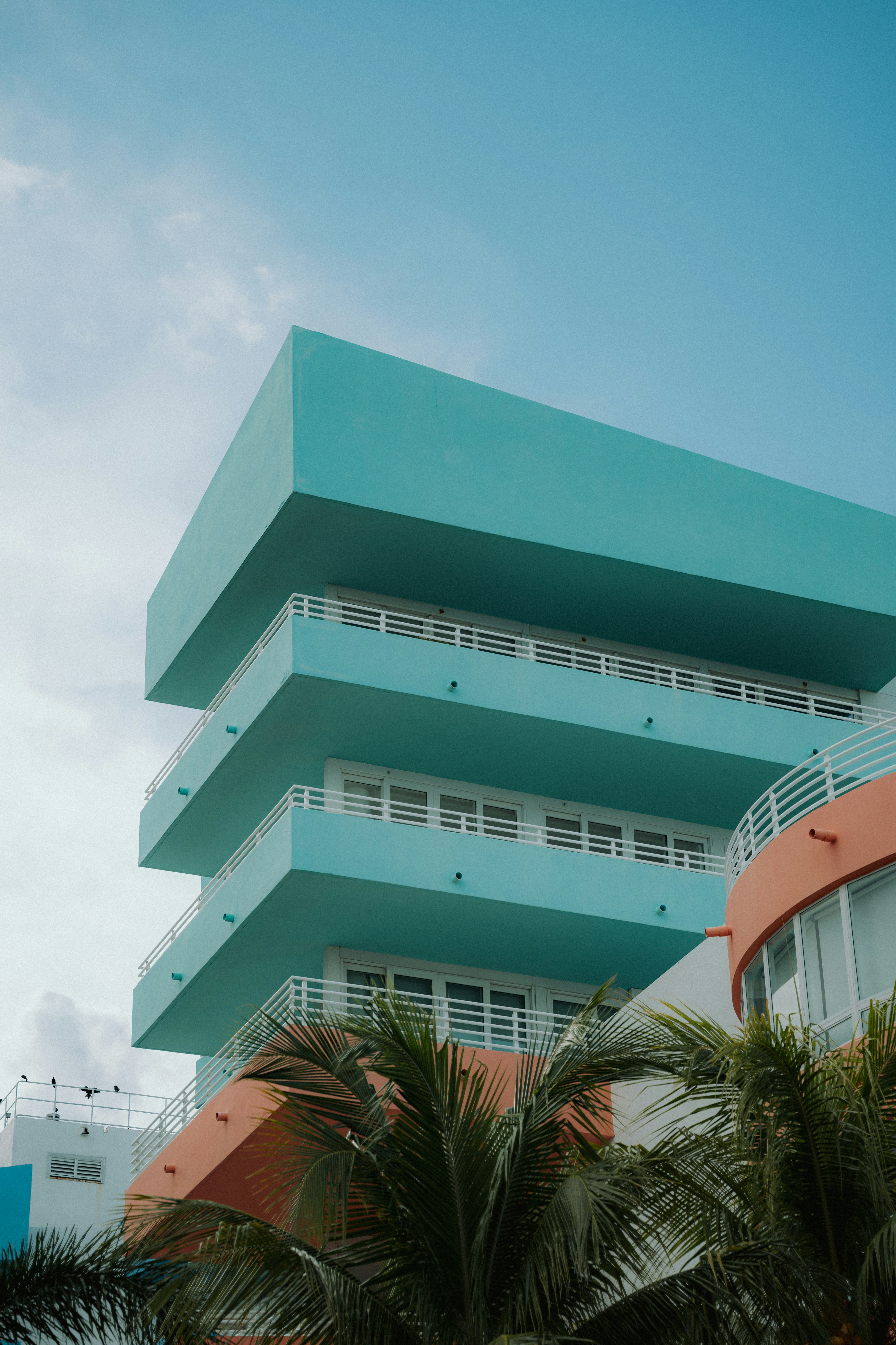 Turquoise building with balconies against blue sky photo – Free Palm ...