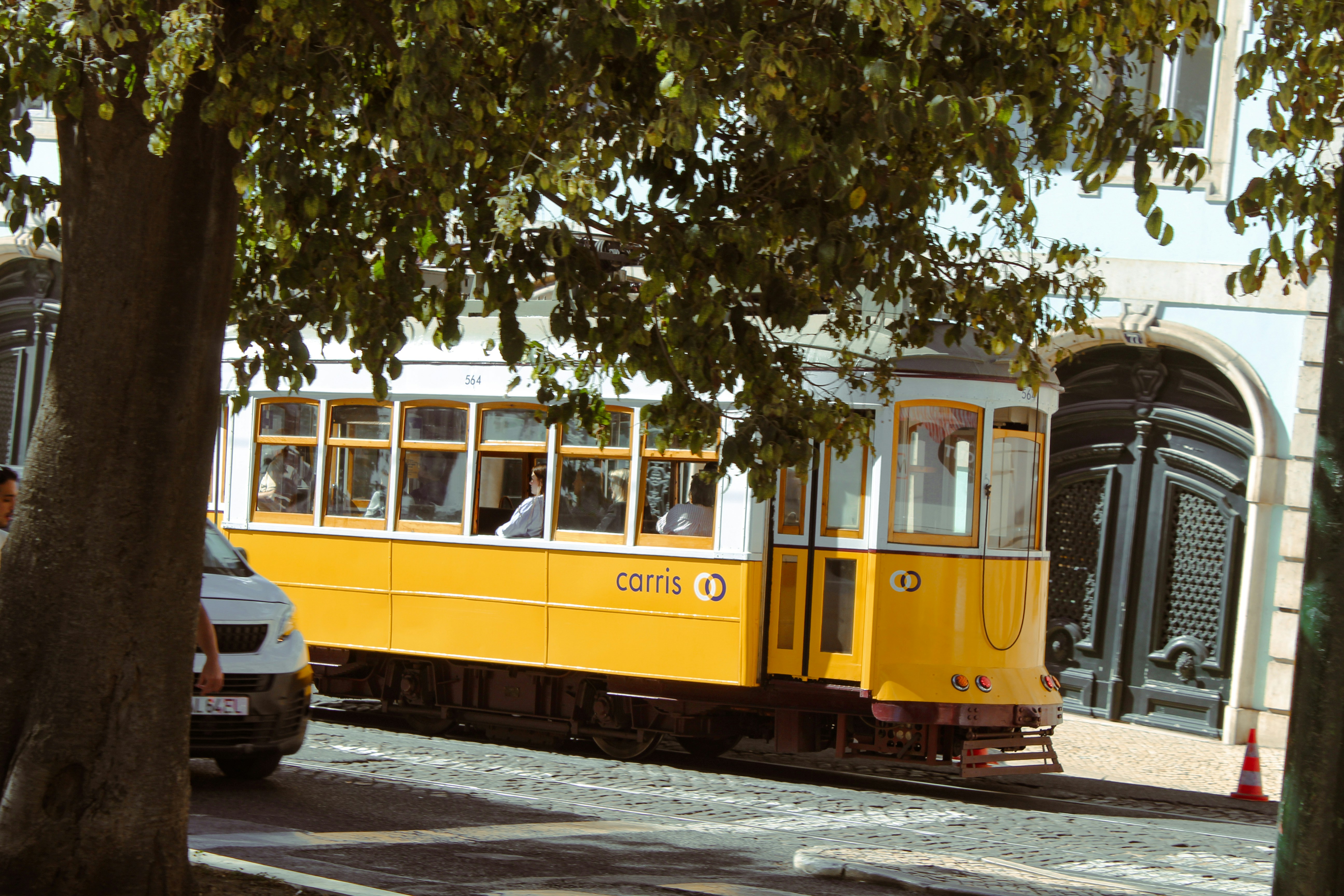 Yellow tram car on a city street.