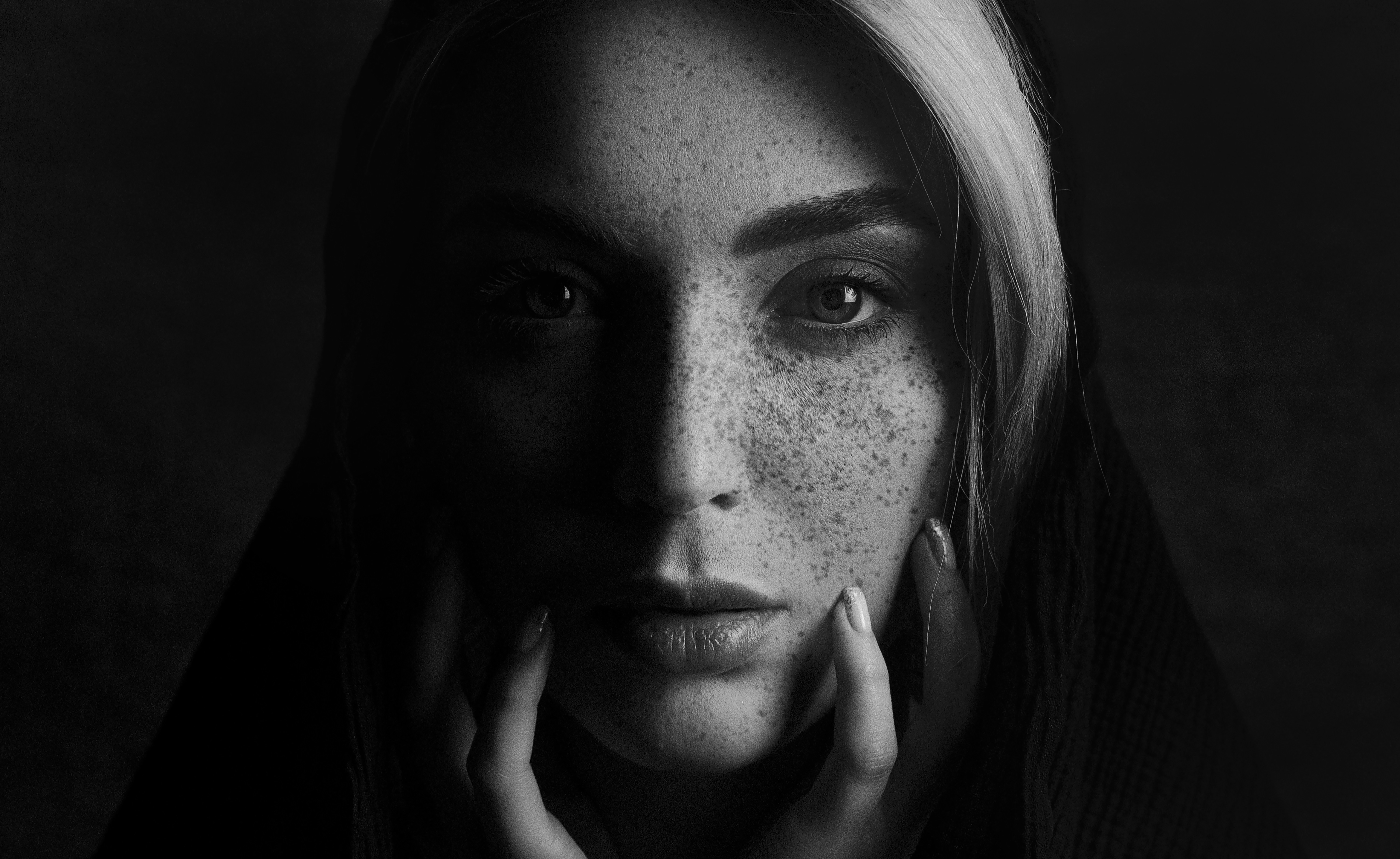 Black and white portrait of a woman with freckles.