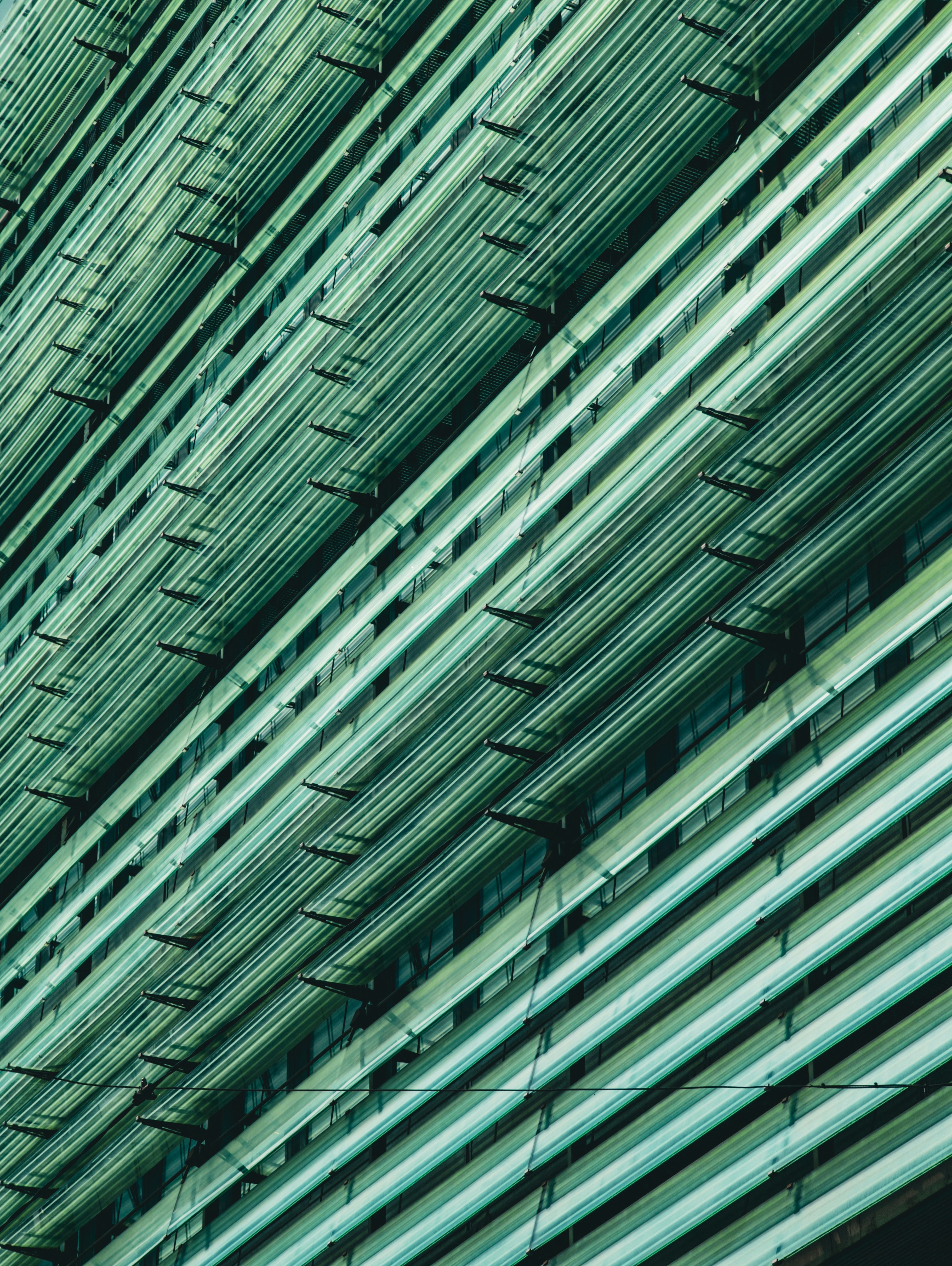 Abstract representation of a modern building facade, showcasing layered glass panels and structural elements in a rhythmic pattern.