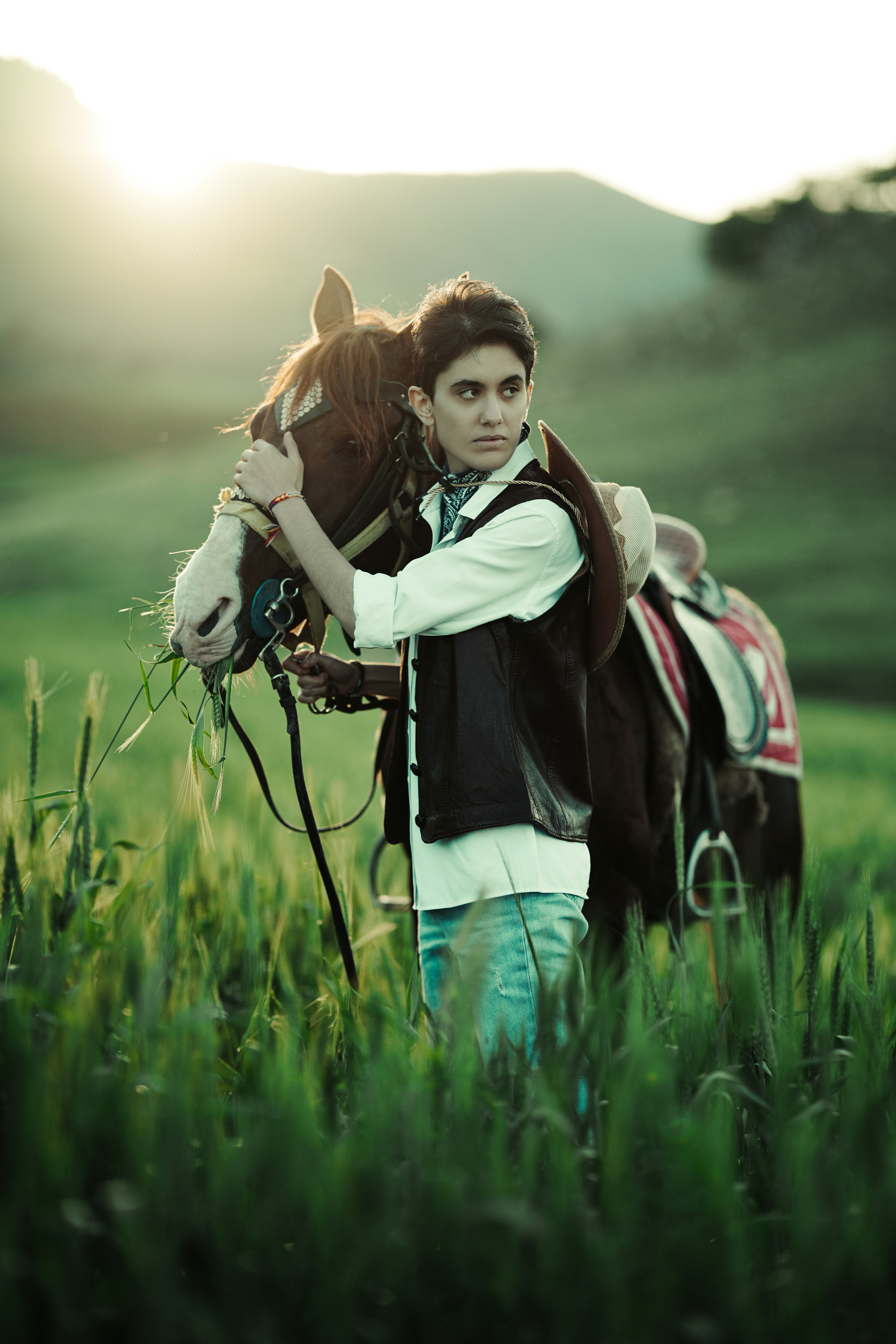 Golden Hour Embrace: A Rider Paired with a Horse in a Verdant Field