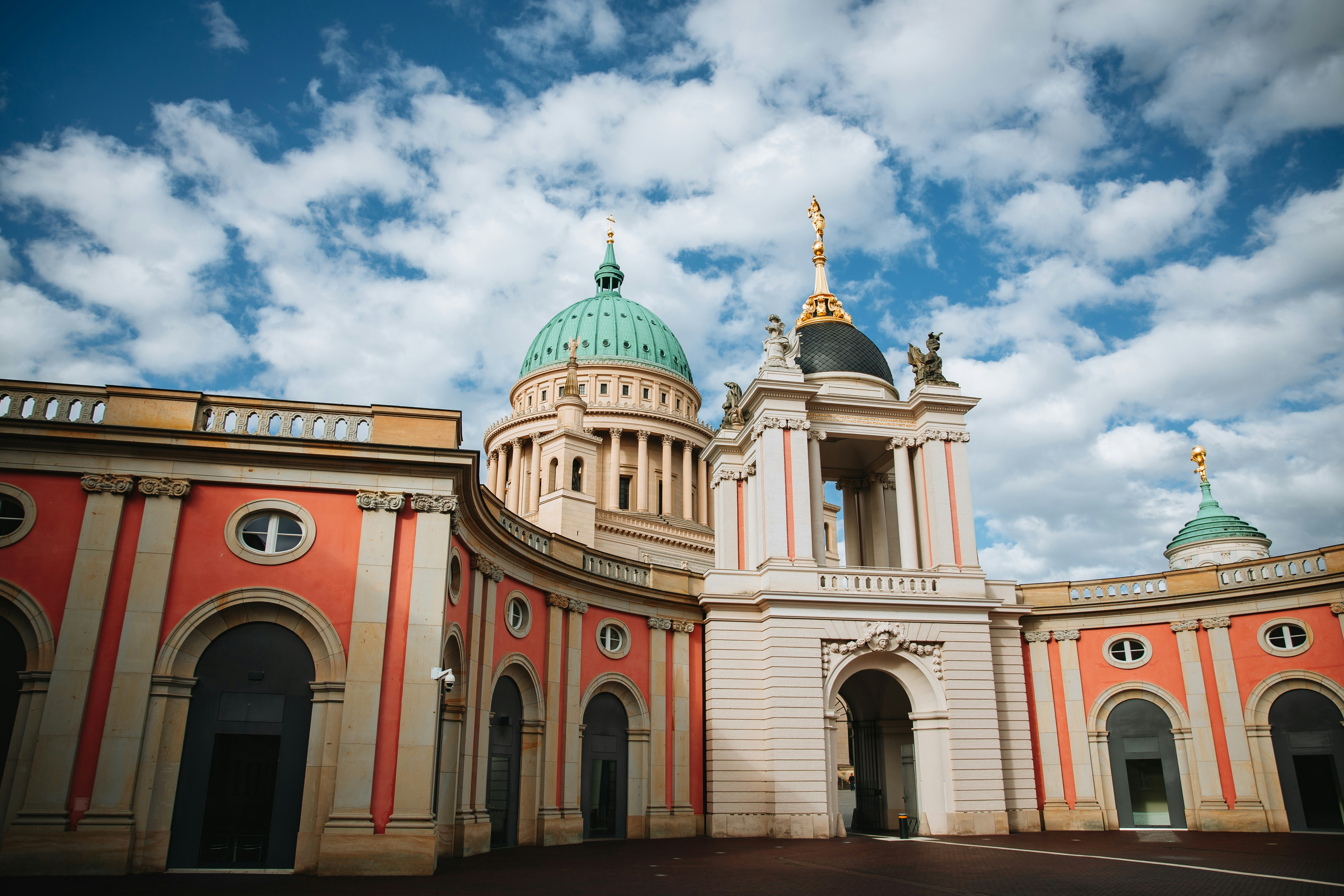 Baroque palace with green domes under blue sky