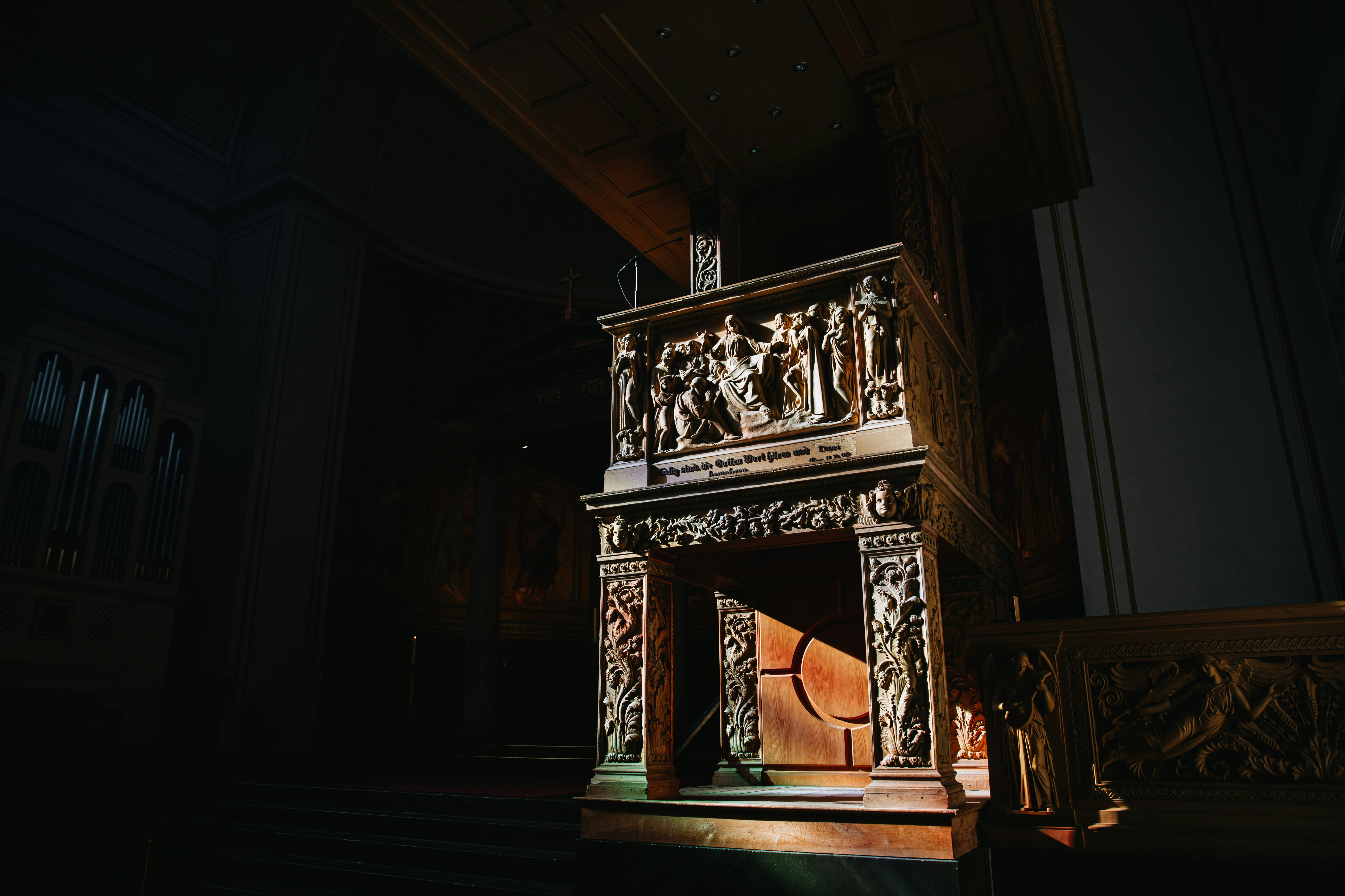 Ornate wooden sarcophagus with detailed carvings in dim light.