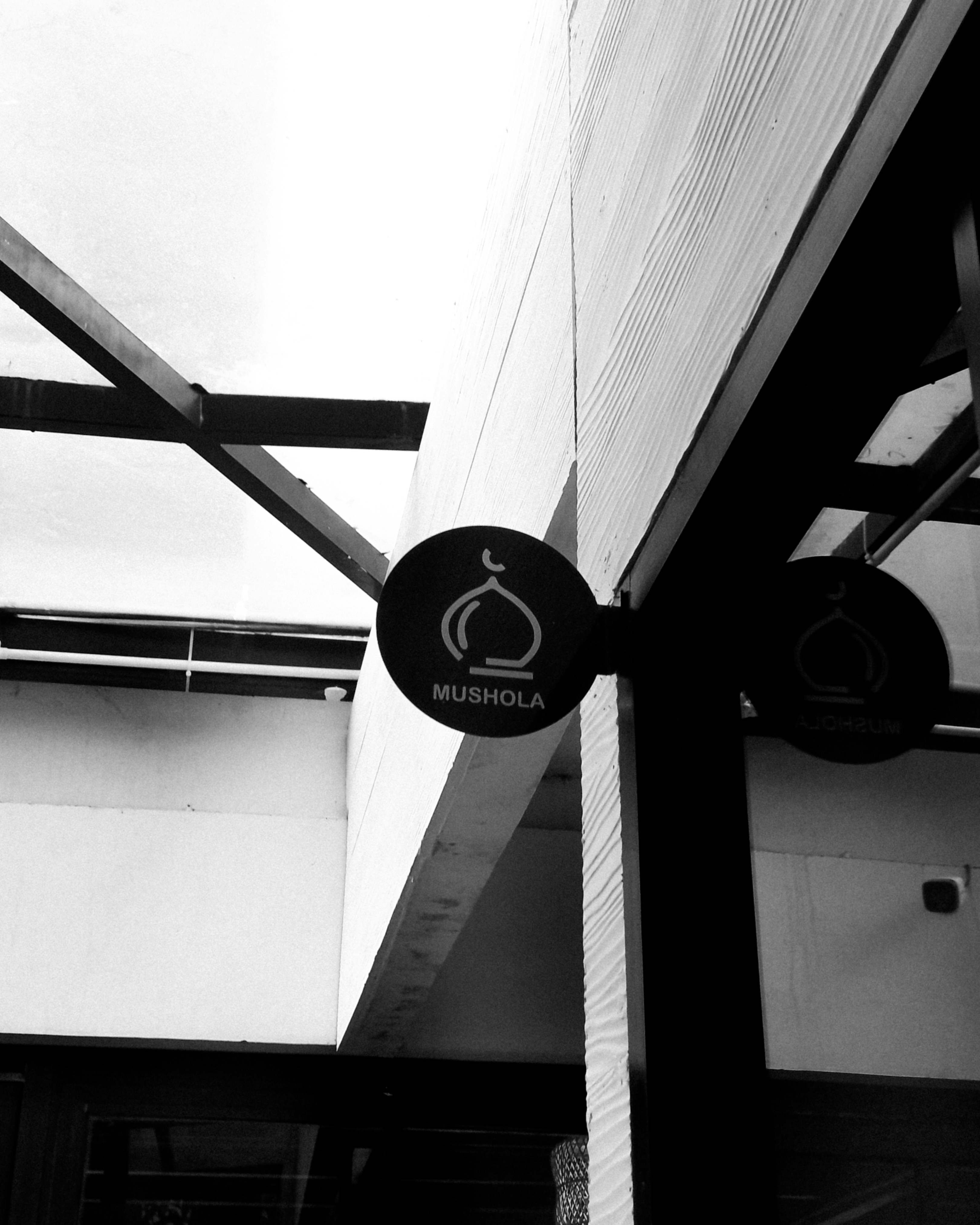 Mushola sign on a modern building exterior