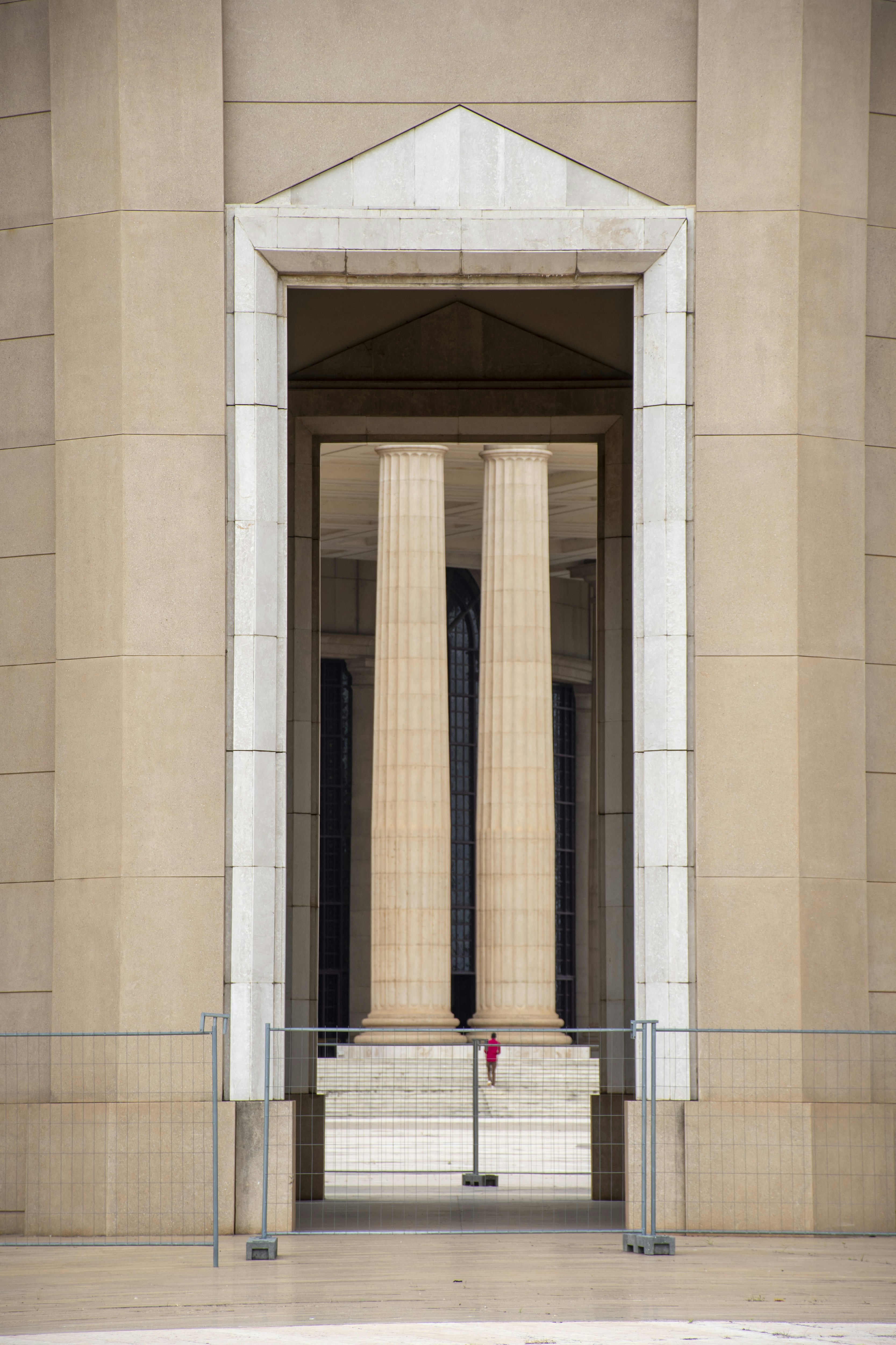 pilier de la basilique notre dame de la paix de Yamoussokro | Two tall columns stand framed within an archway.