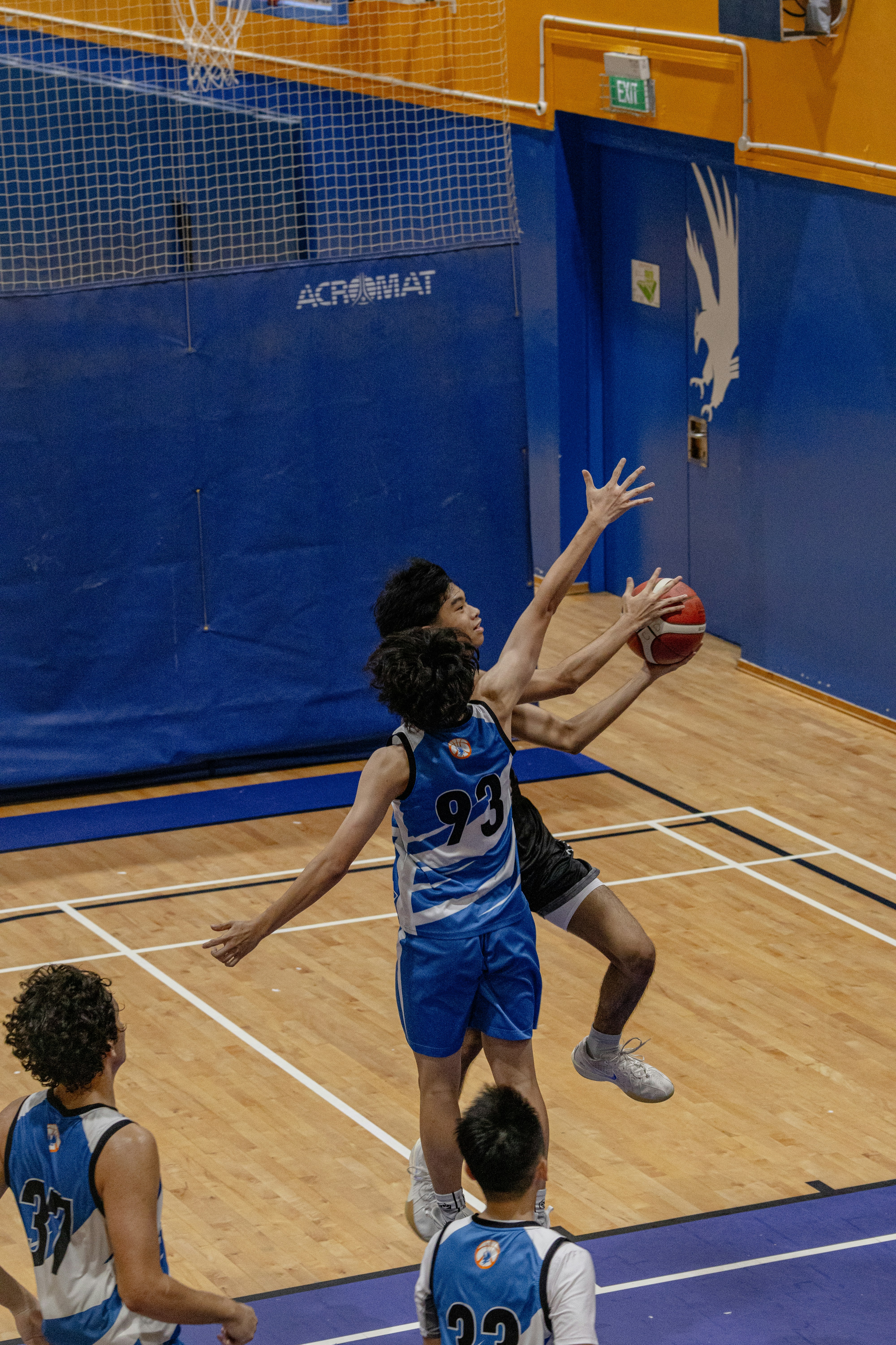 Basketball players reaching for the ball during game.