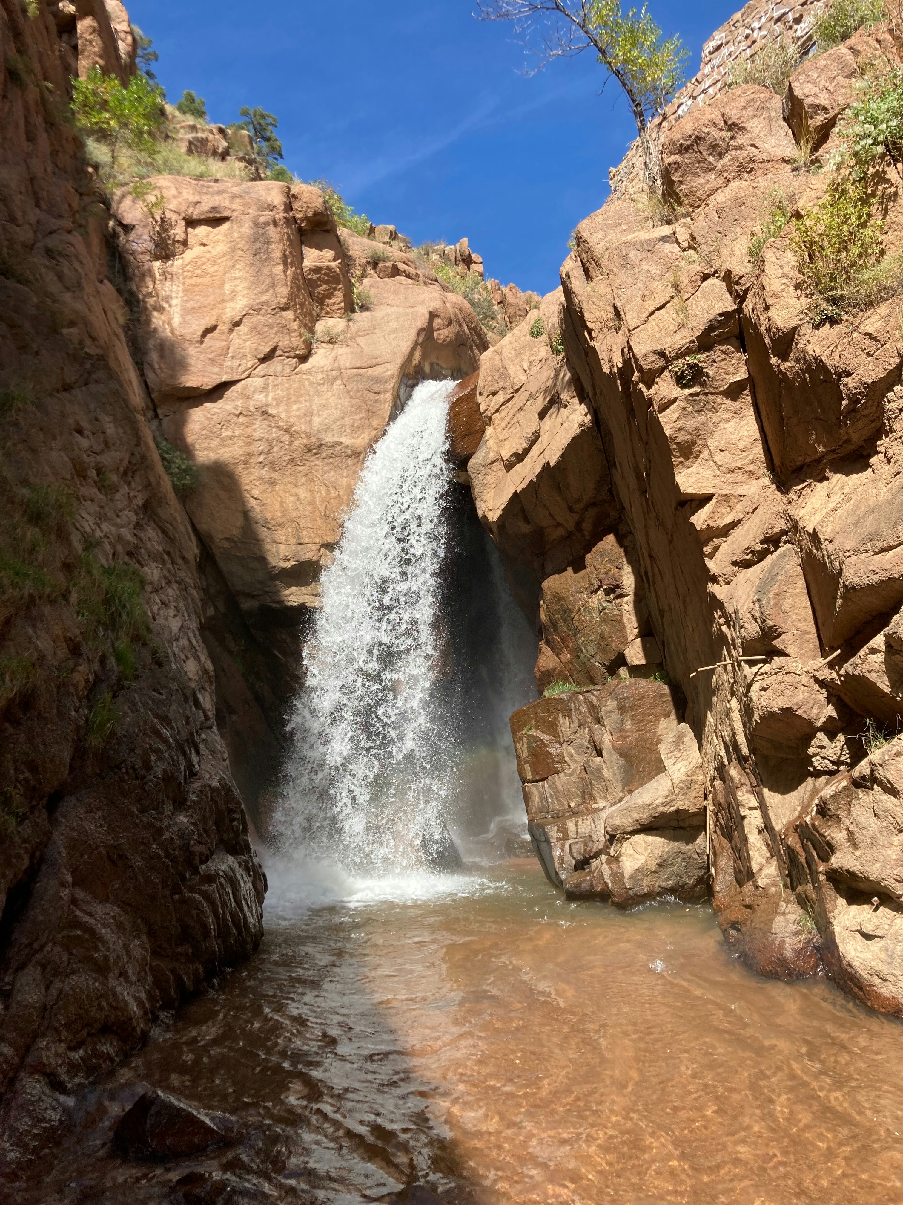 Rainbow Falls also known as Graffiti Falls, , historic site, faint rainbow seen in the mist of the waterfall. Last day of the season 2025, September 28, 2025 | Waterfall cascading down rocky canyon walls