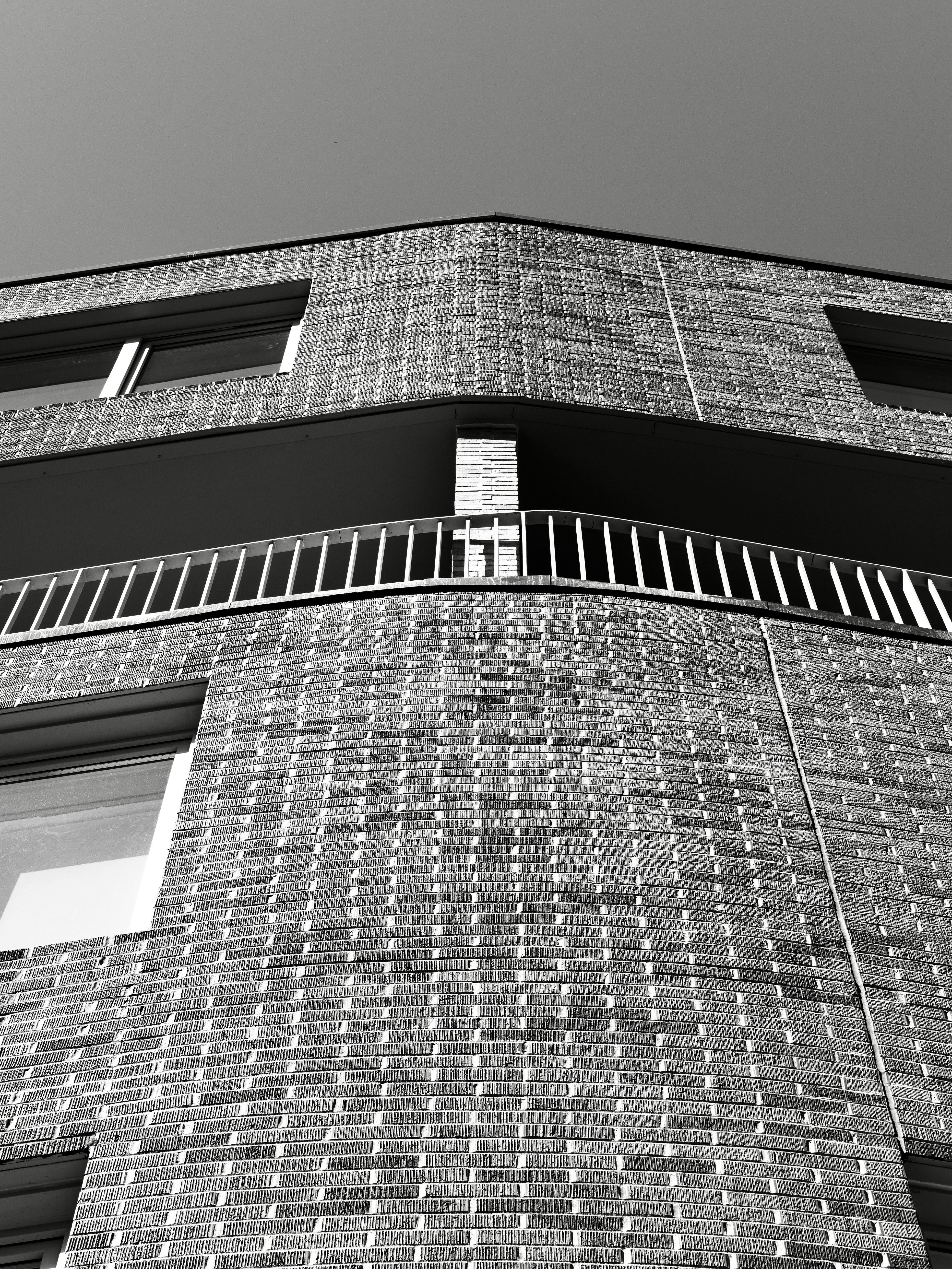 Brick facade of an apartment building | Modern brick building with balconies and windows