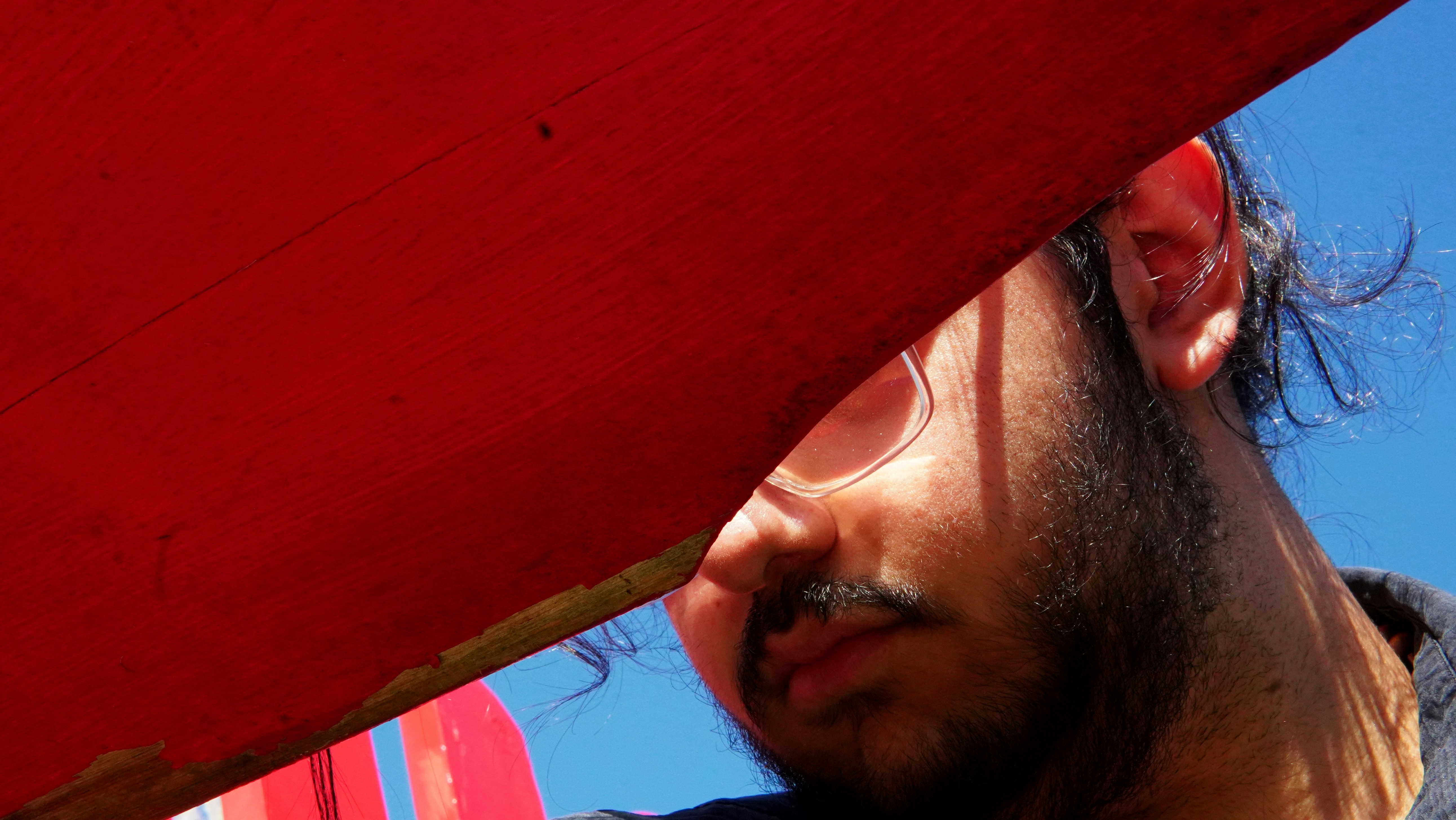 Man with mustache under a red canopy