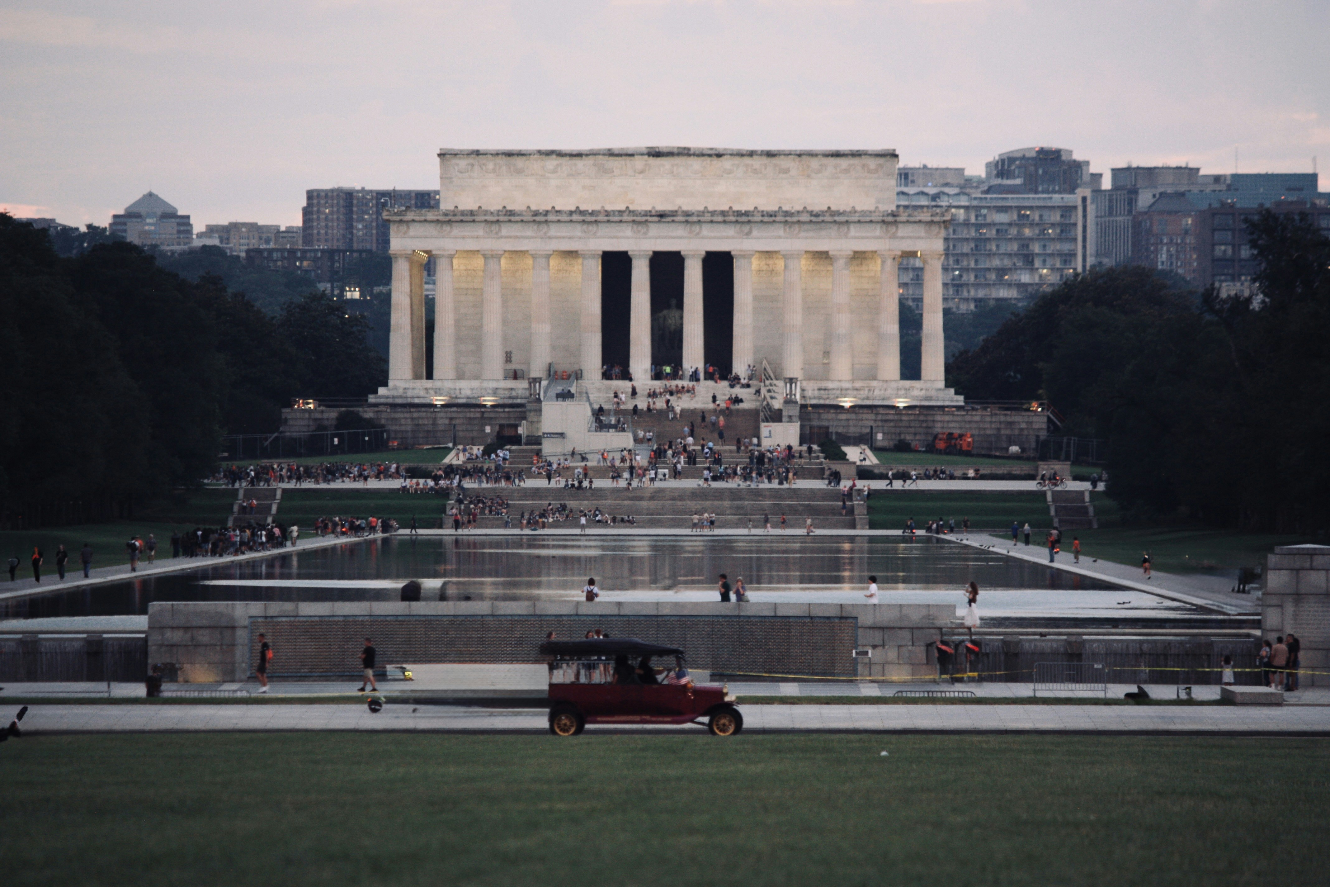 Lincoln memorial with reflecting pool and vintage car.